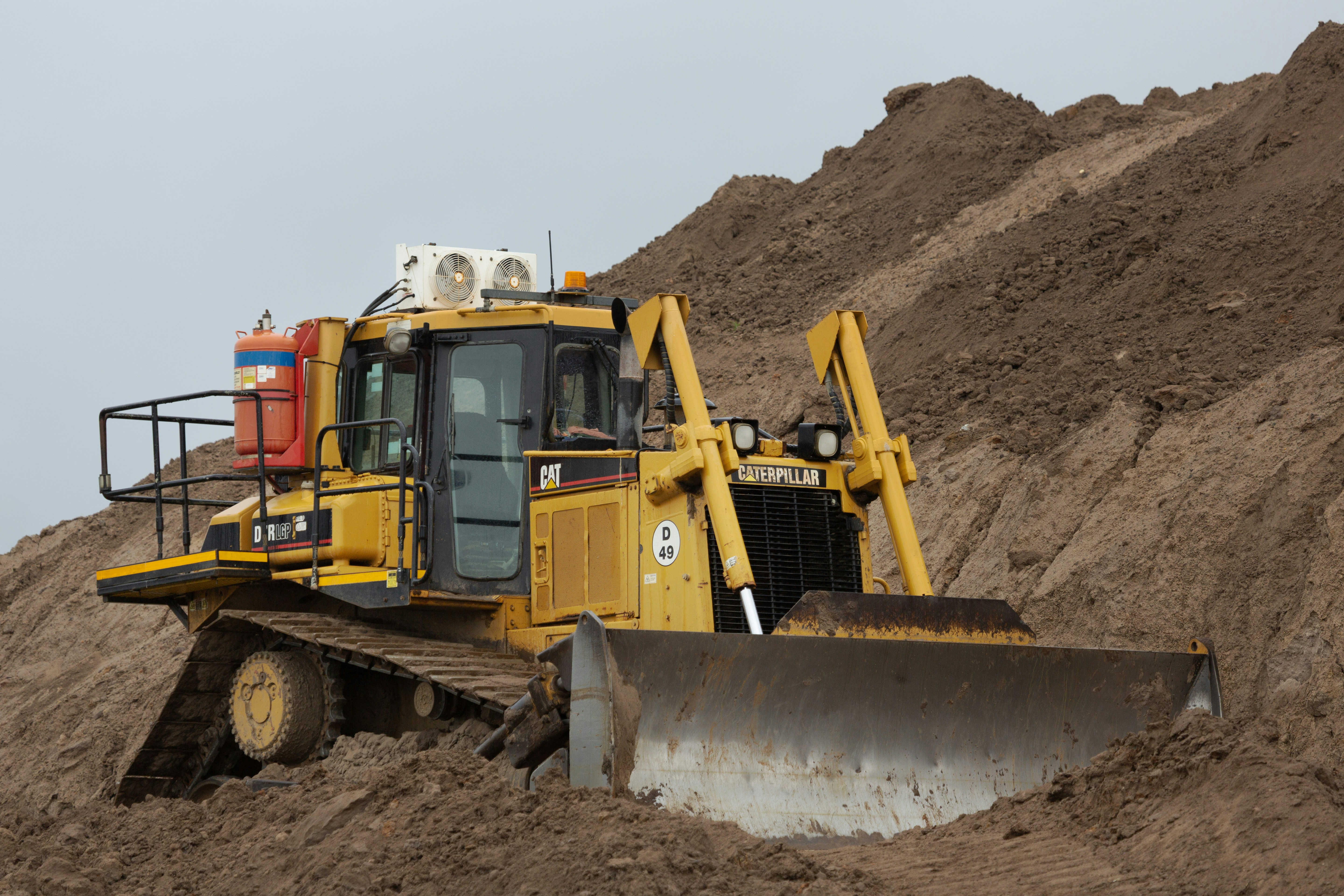 Giant Yellow Bulldozer Rims the Earthen Ramp