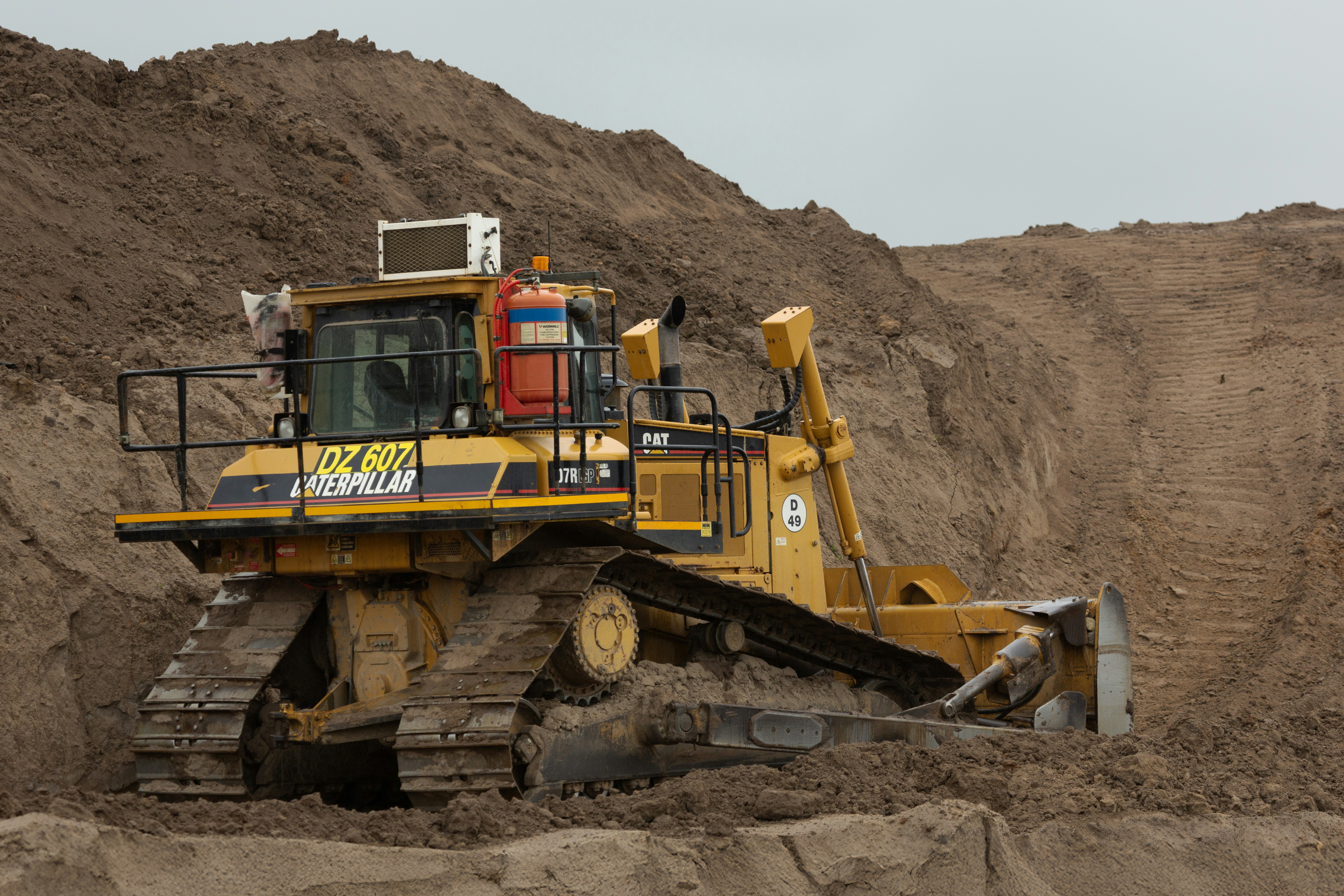Sunlit Giant: A Crawler Dozer Rests Amid Mounded Earth