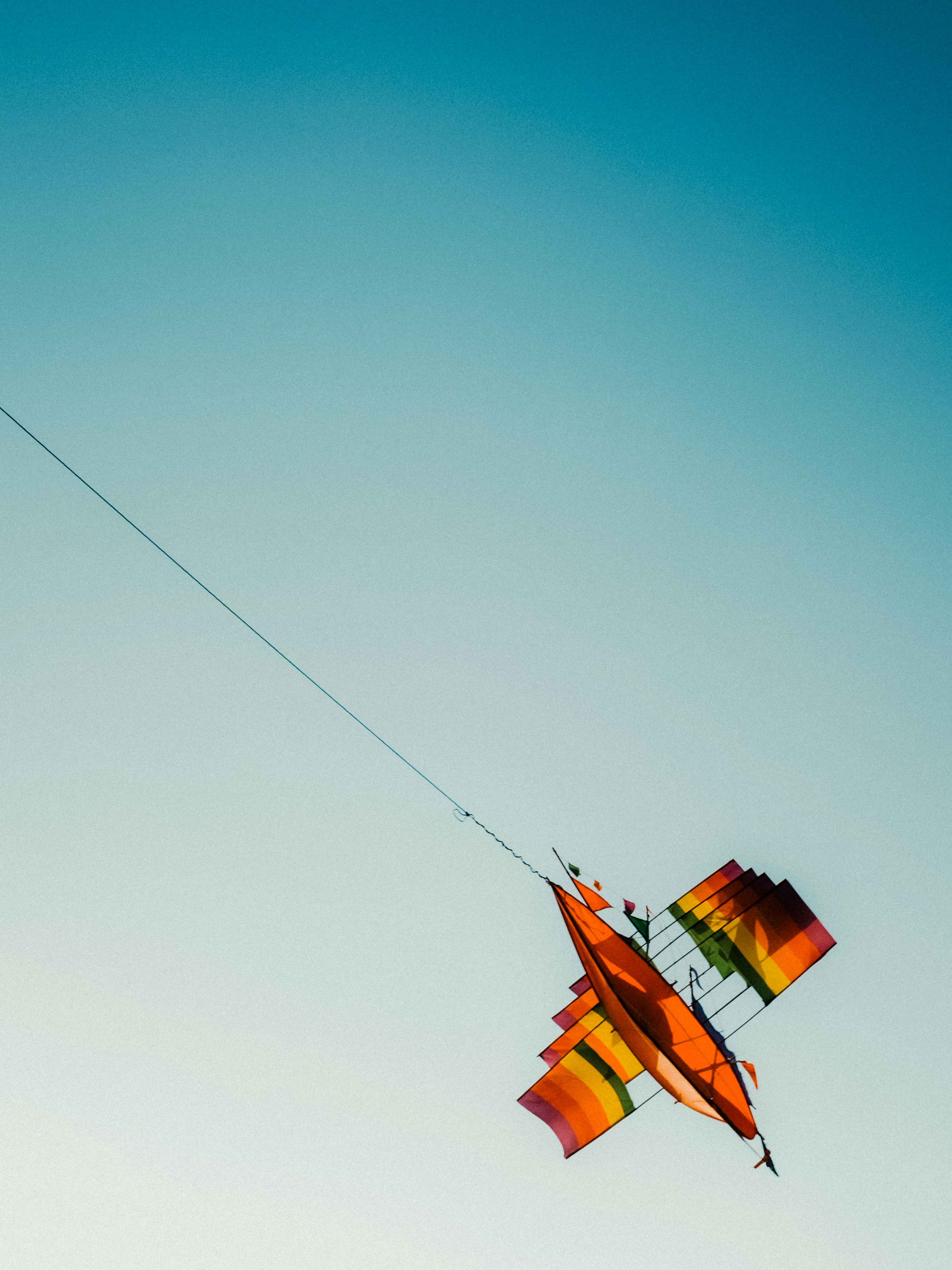 Kite in the Sky: A Prism of Color Slicing Through a Clear Blue
