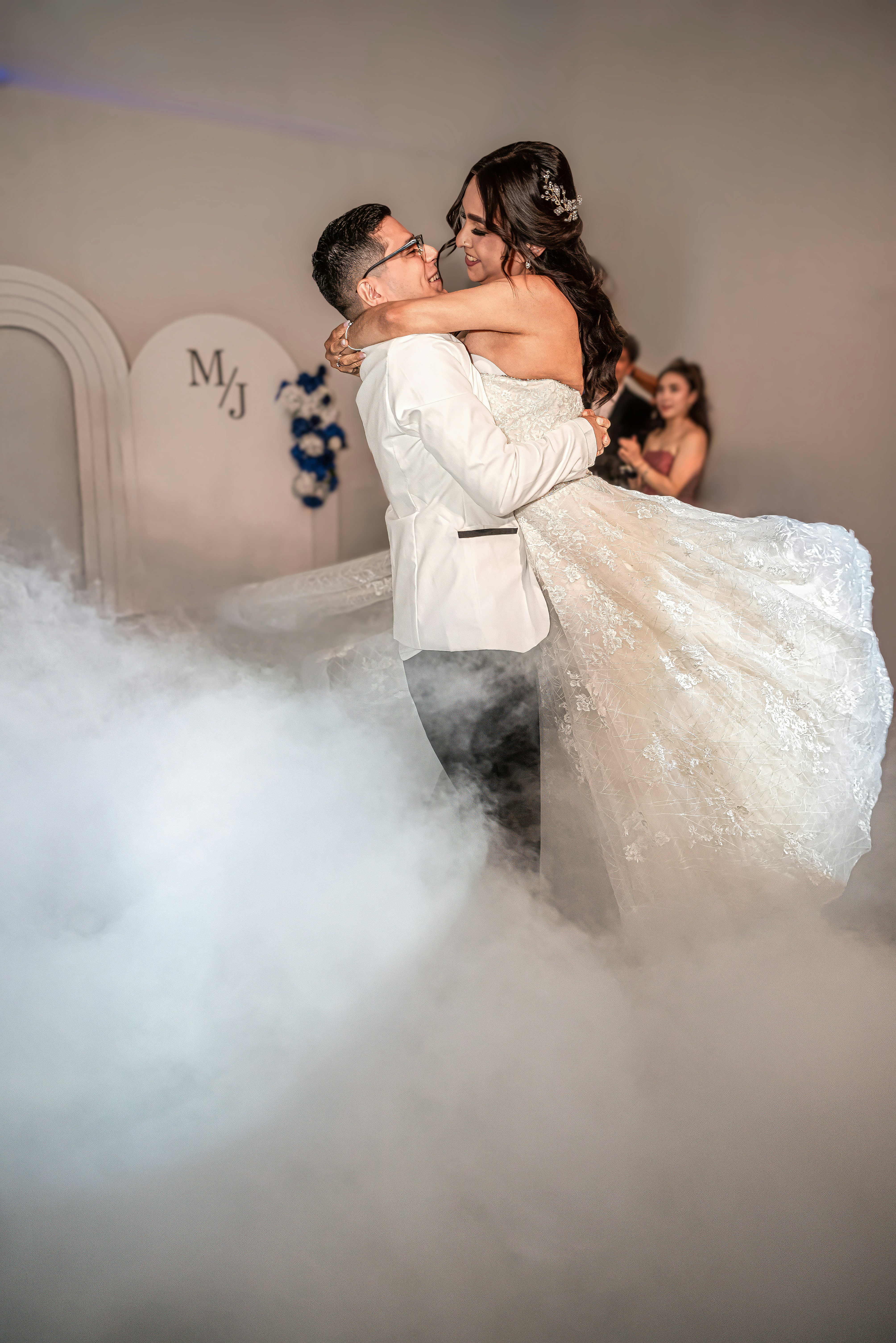Partnered in white: a graceful dance through a misty reception