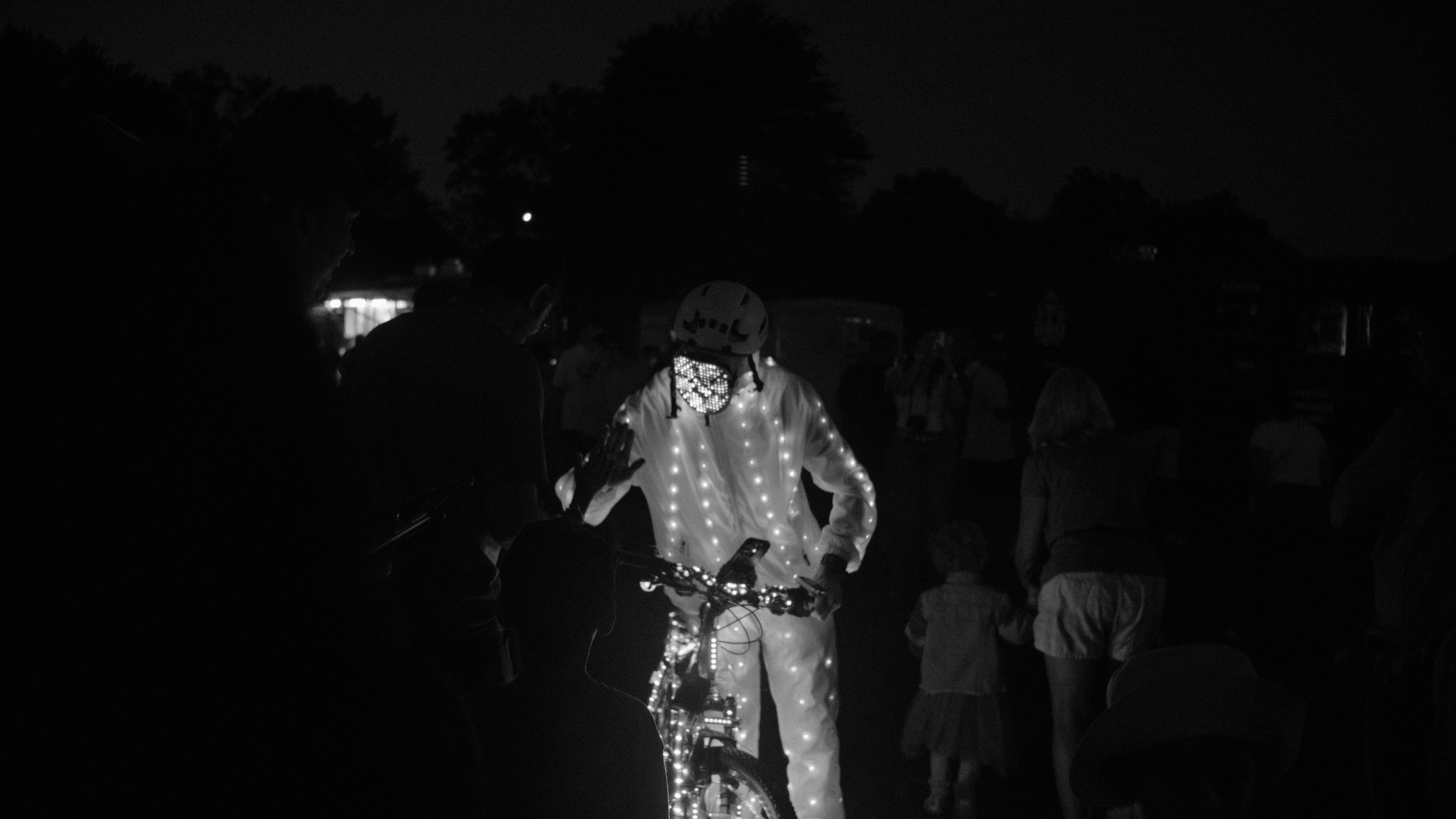 Neon-lined Performer in the Night Carnival