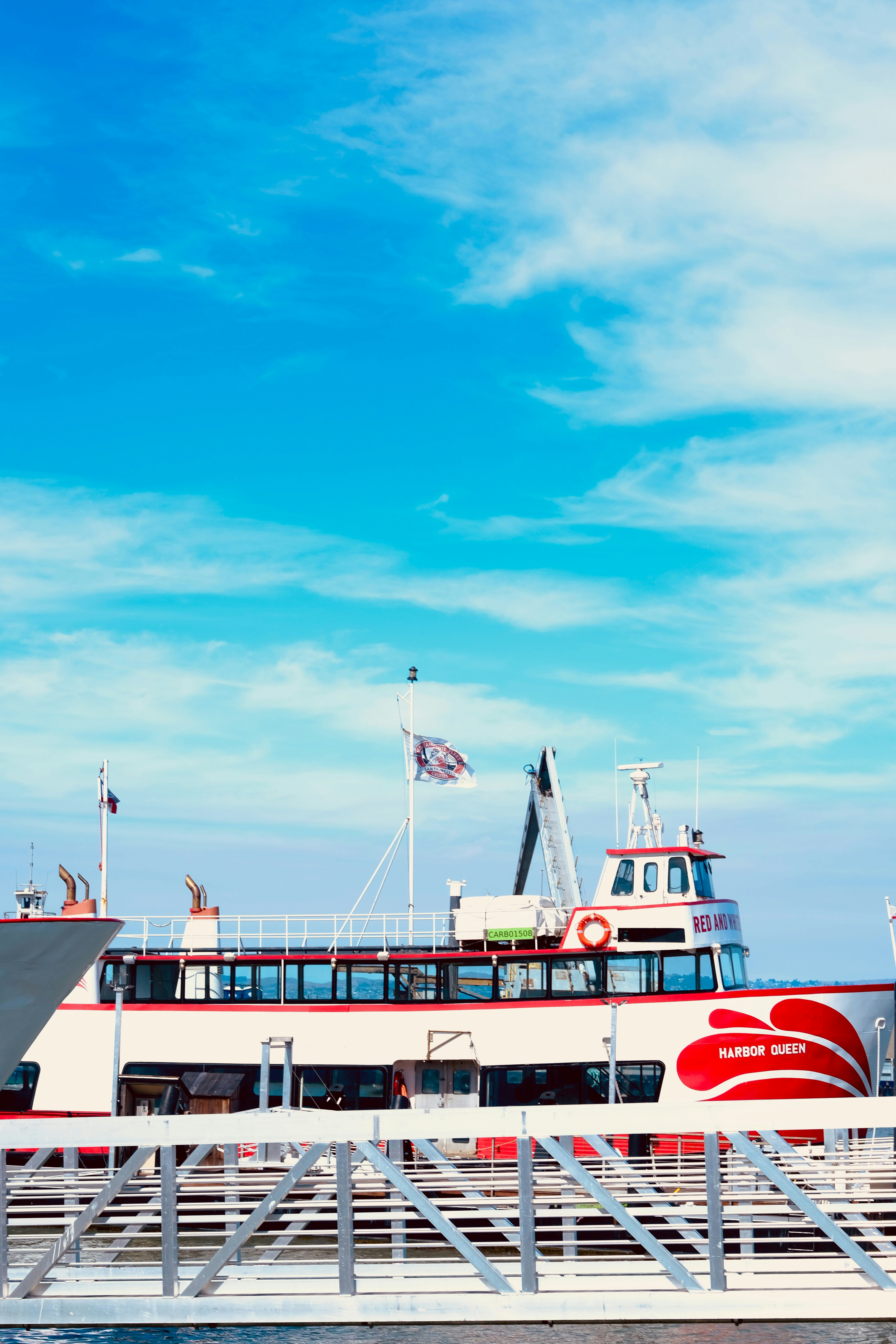 Harbor Queen at Docks: Bright Sky and Red-Trim Ferry