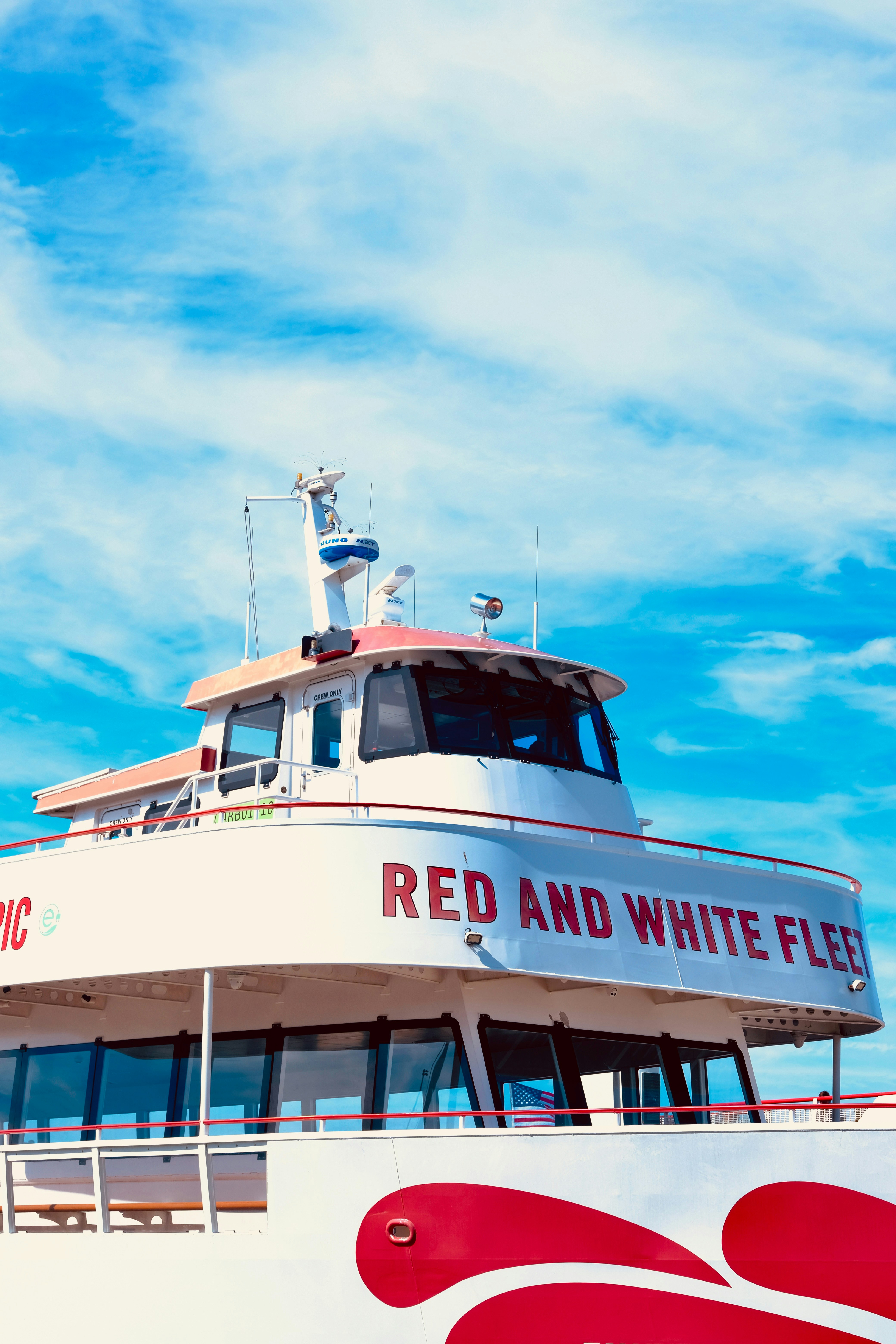 Bannered Vessel: A Bright Ferry Cut Through a Sky of Blue