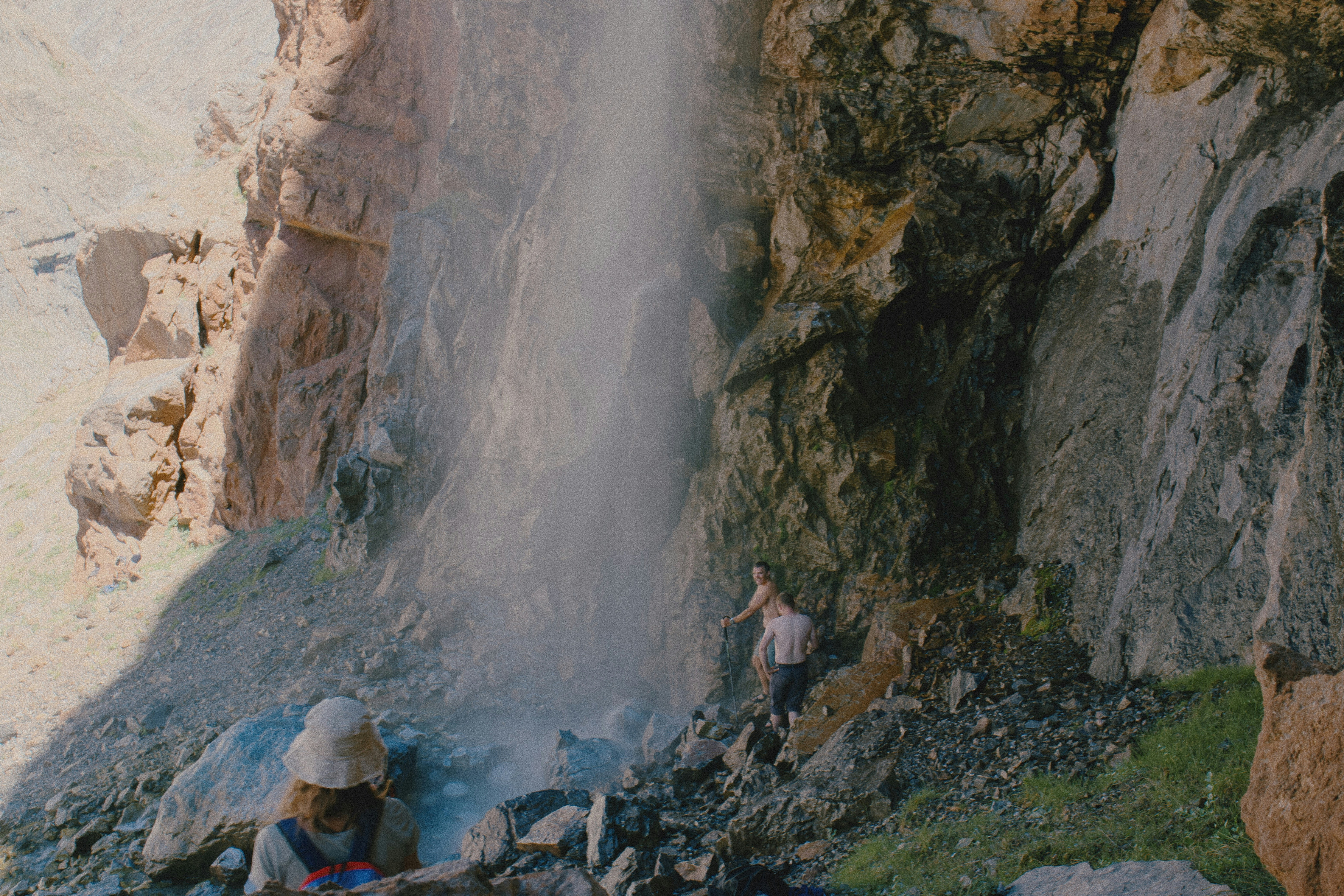 Cascade of Resolve: Two hikers at the Base of a Hidden Falls