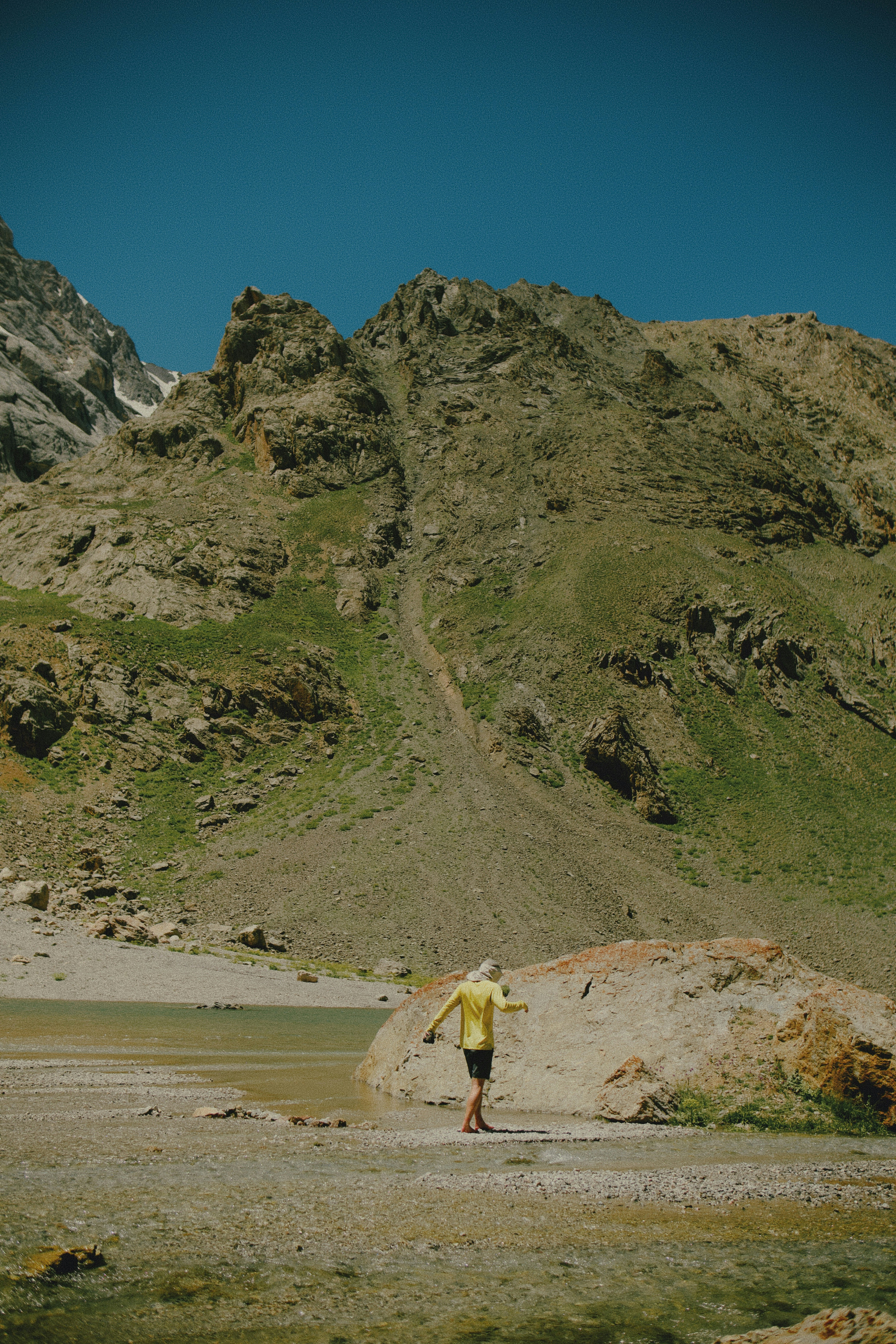 Sunlit Wanderer at the Base of the Green Ridge