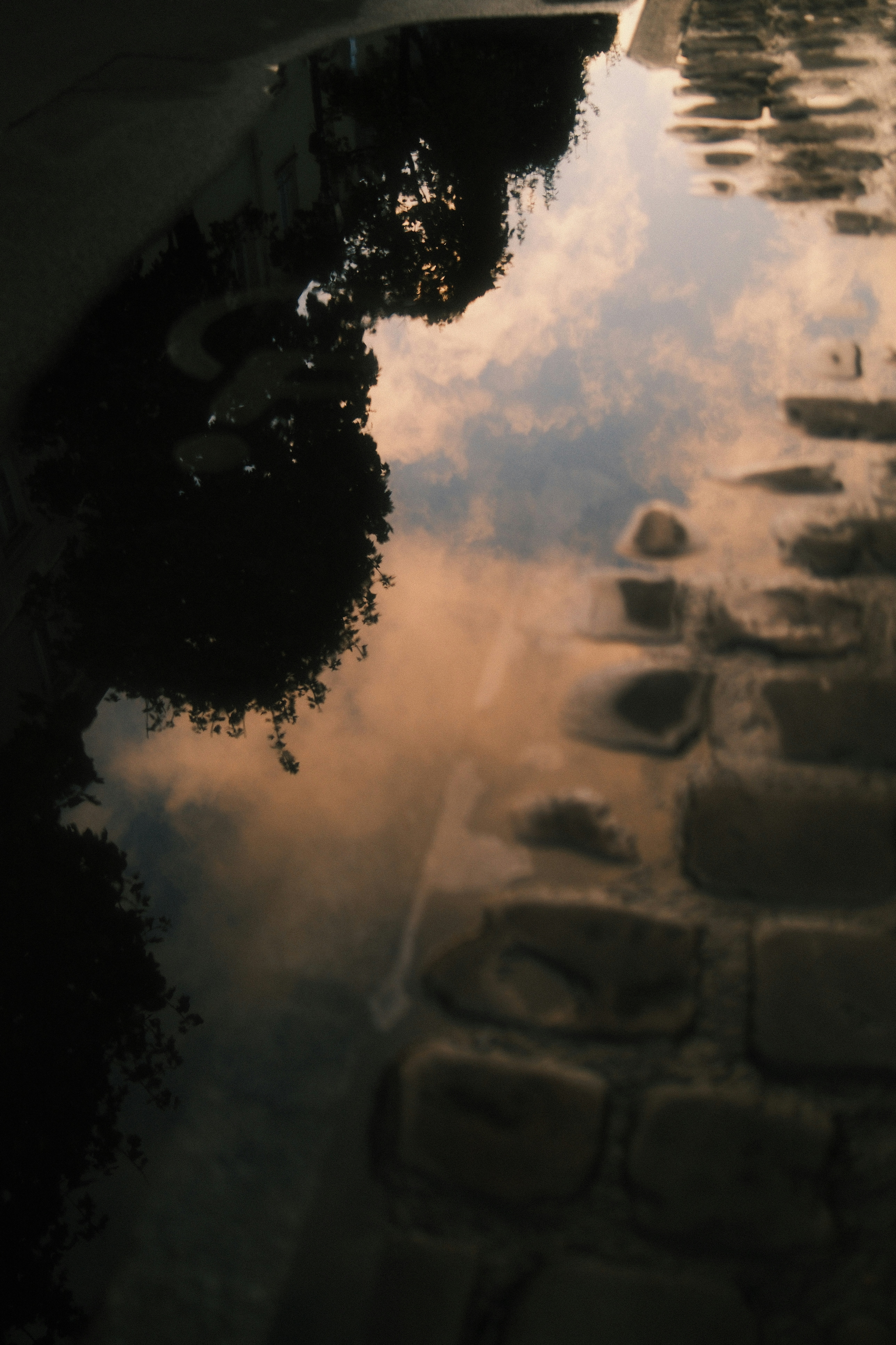 Reflections on stone and sky: a tilted street scene