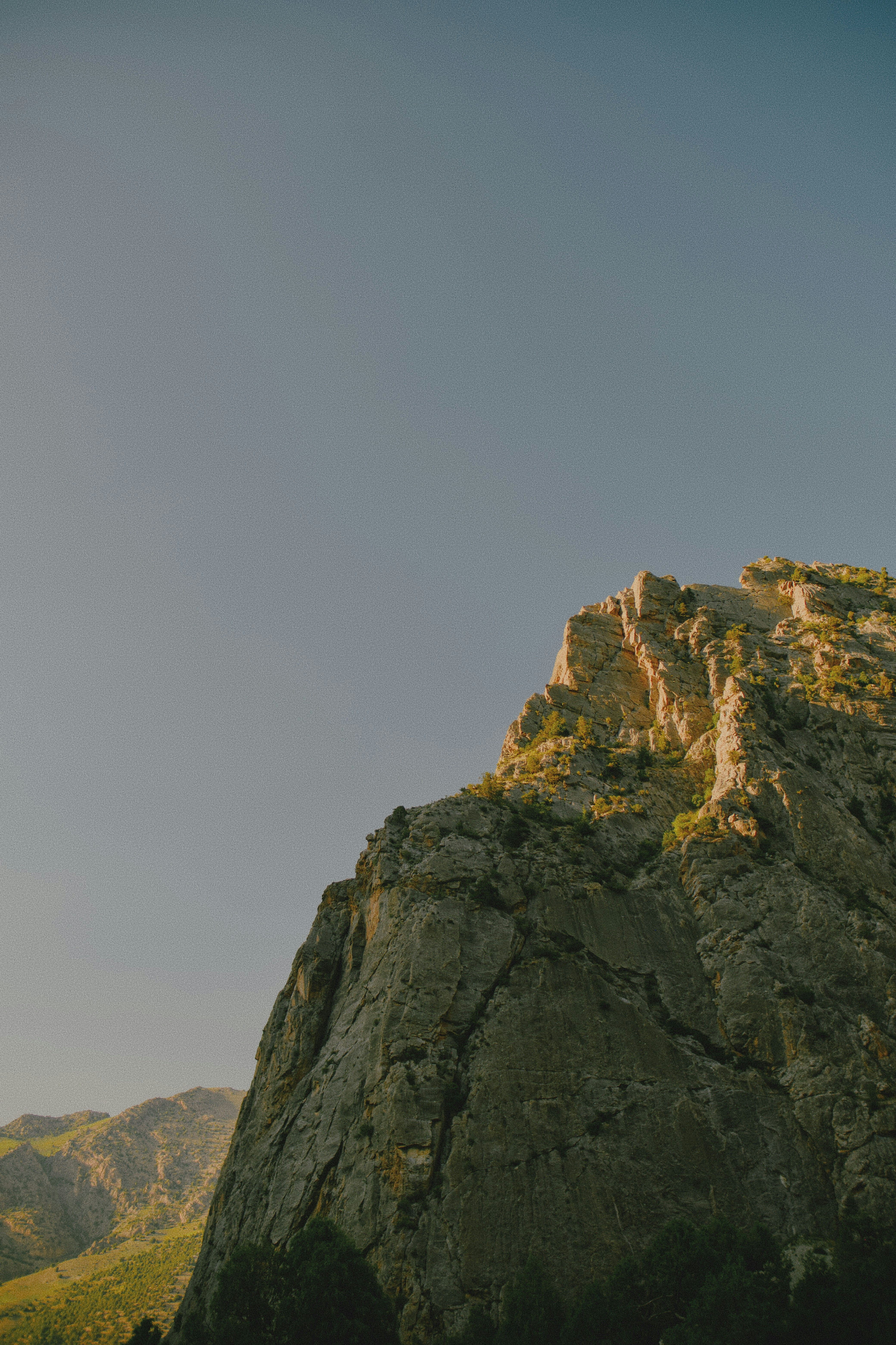 Sunlit Crags: Golden Rock Formations in Quiet Valley