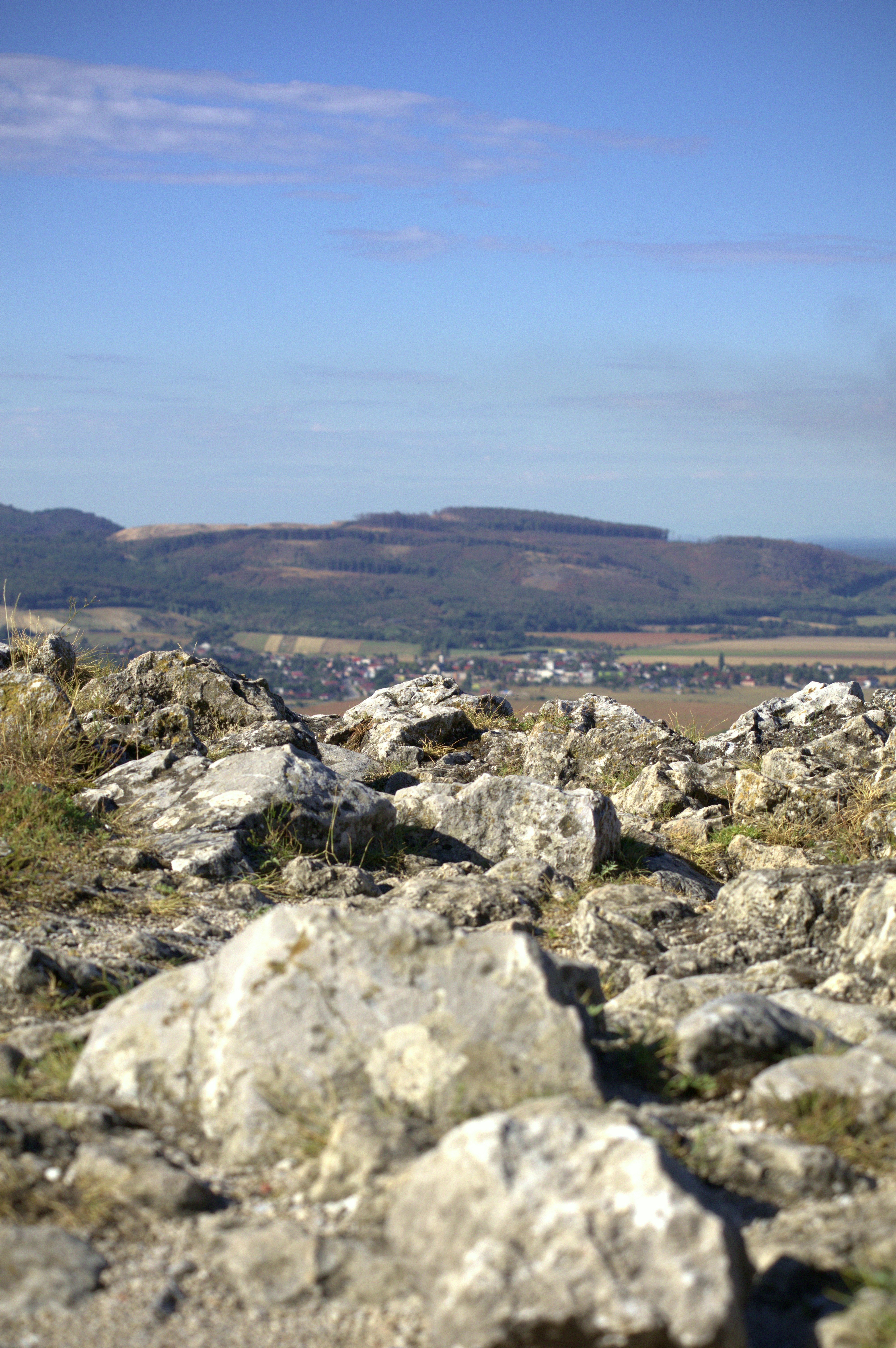 Rugged limestone foreground with distant rolling hills and village