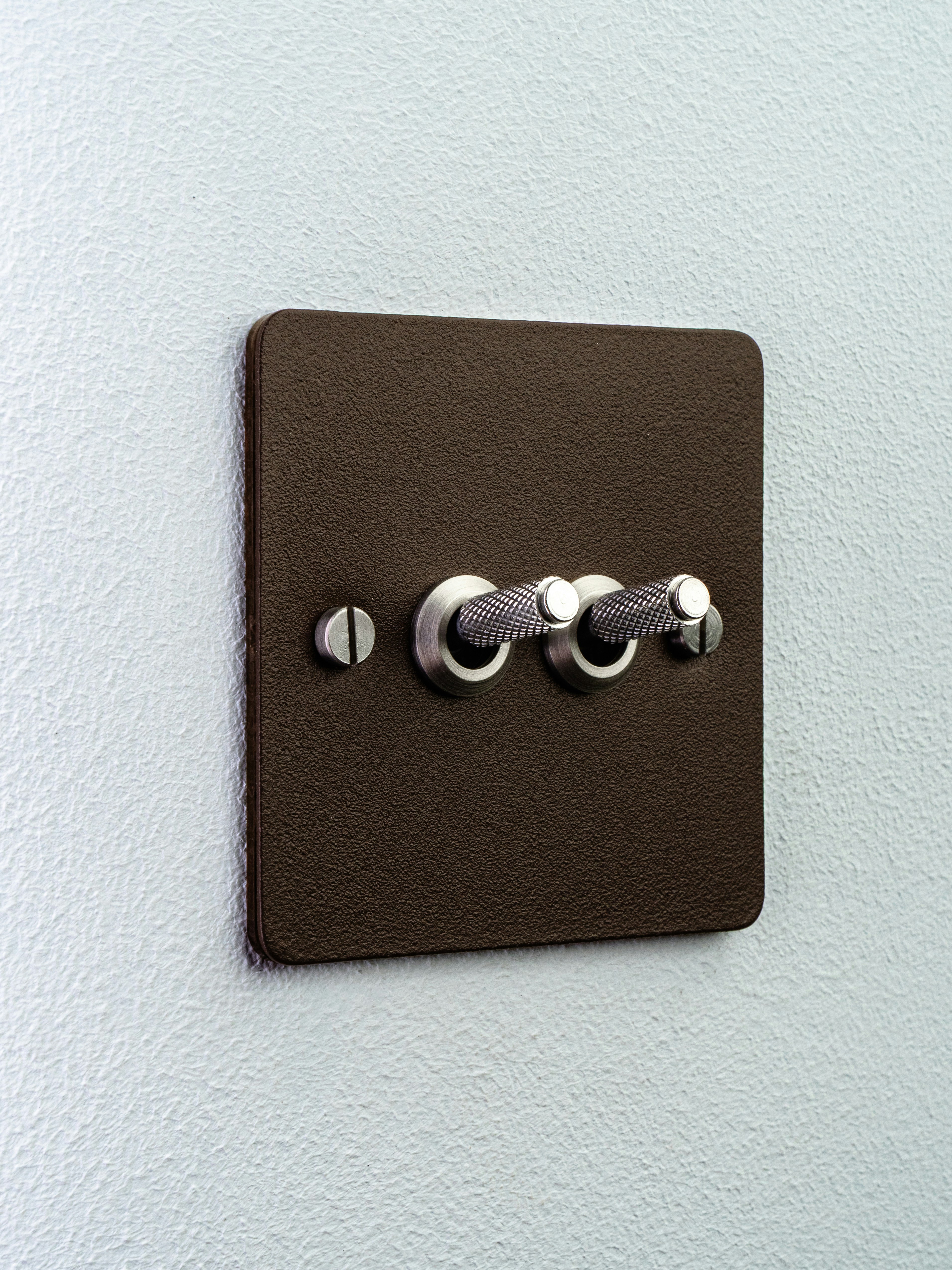 Muted Steel Switches on a Pale Wall