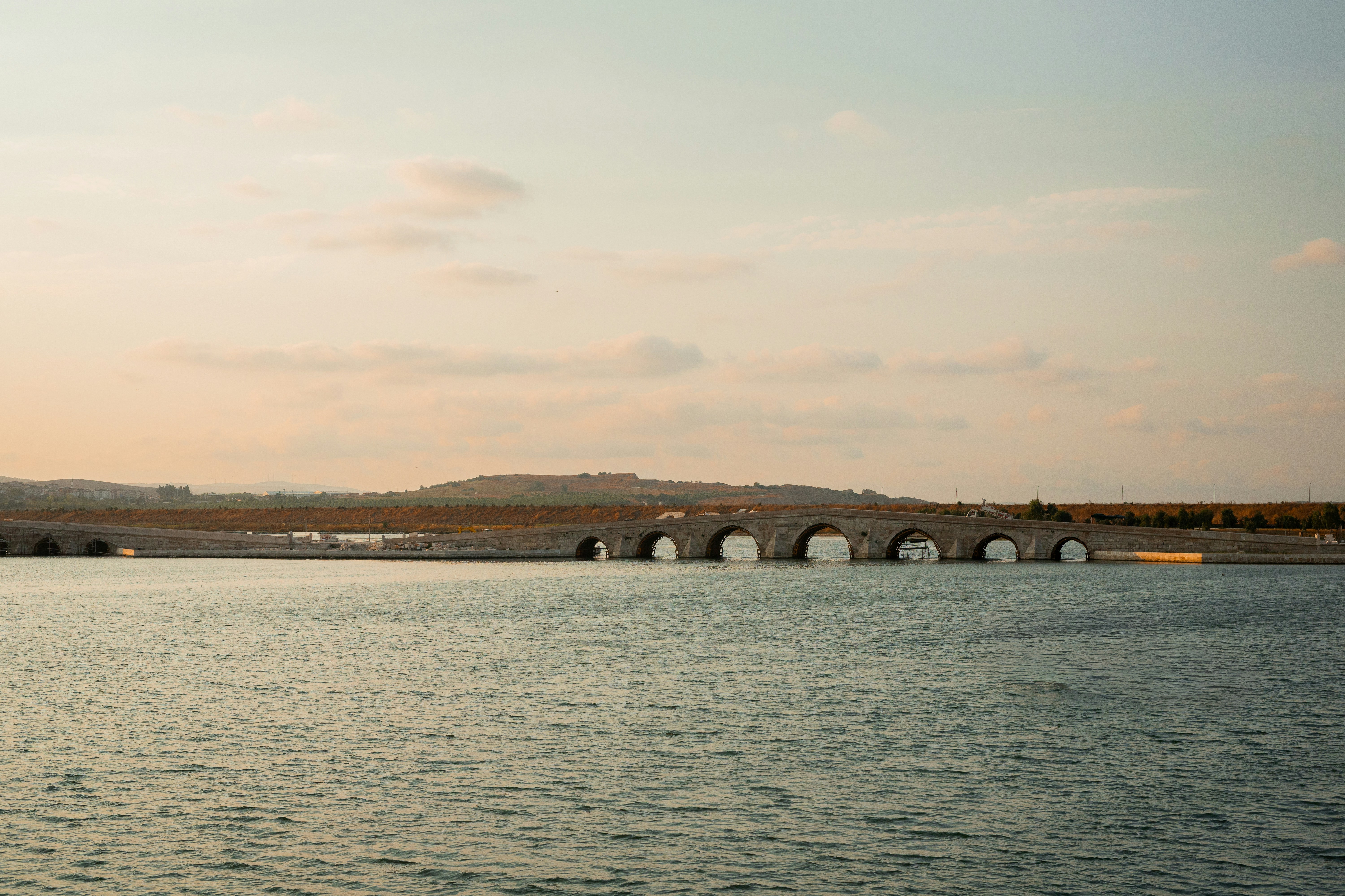 Distant Arcades: A Quiet Bridge Across Calm Waters