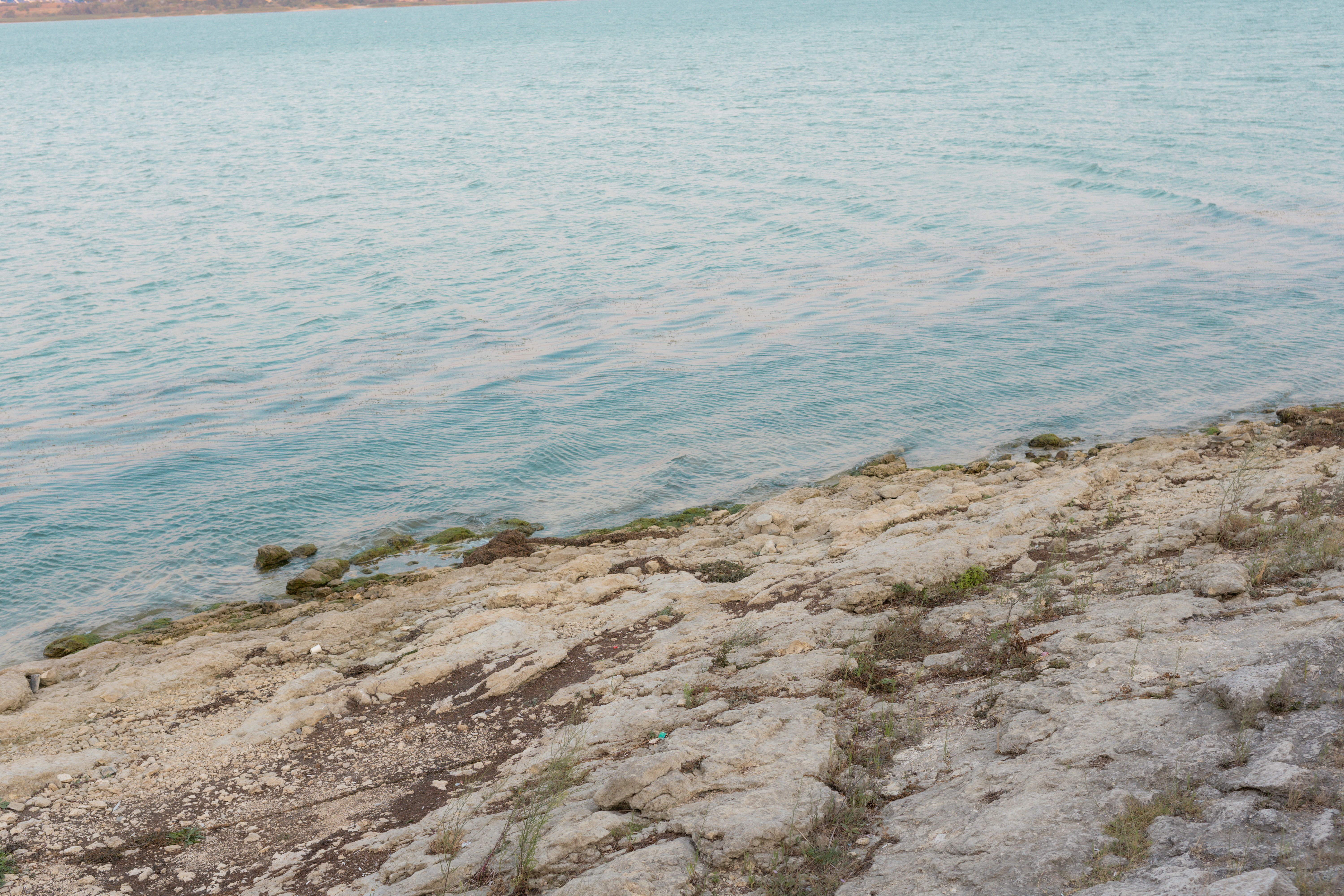 Rugged shoreline meeting tranquil turquoise inlet