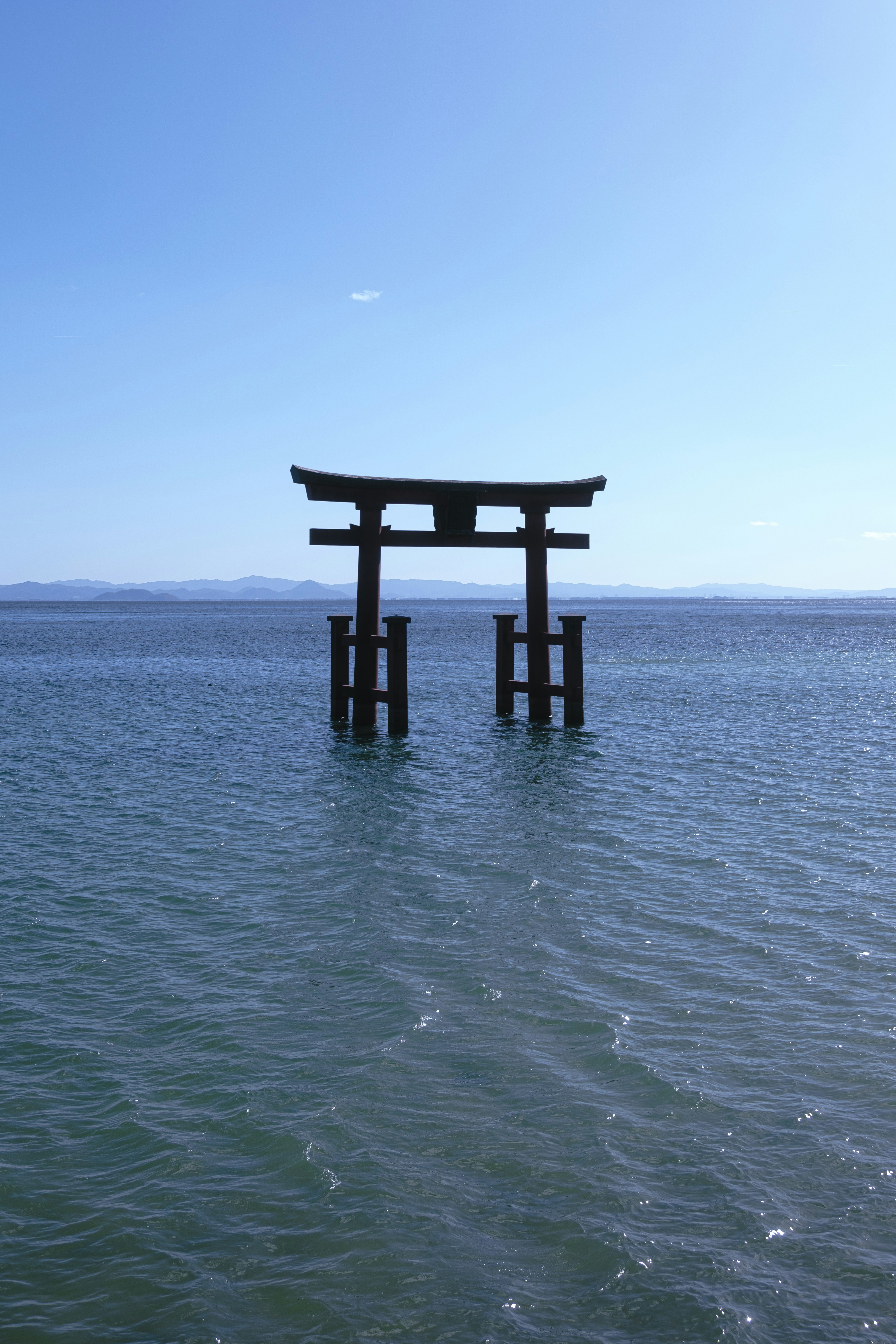 Torii at Distant Horizon: A Thinned Silhouette Over Quiet Seas