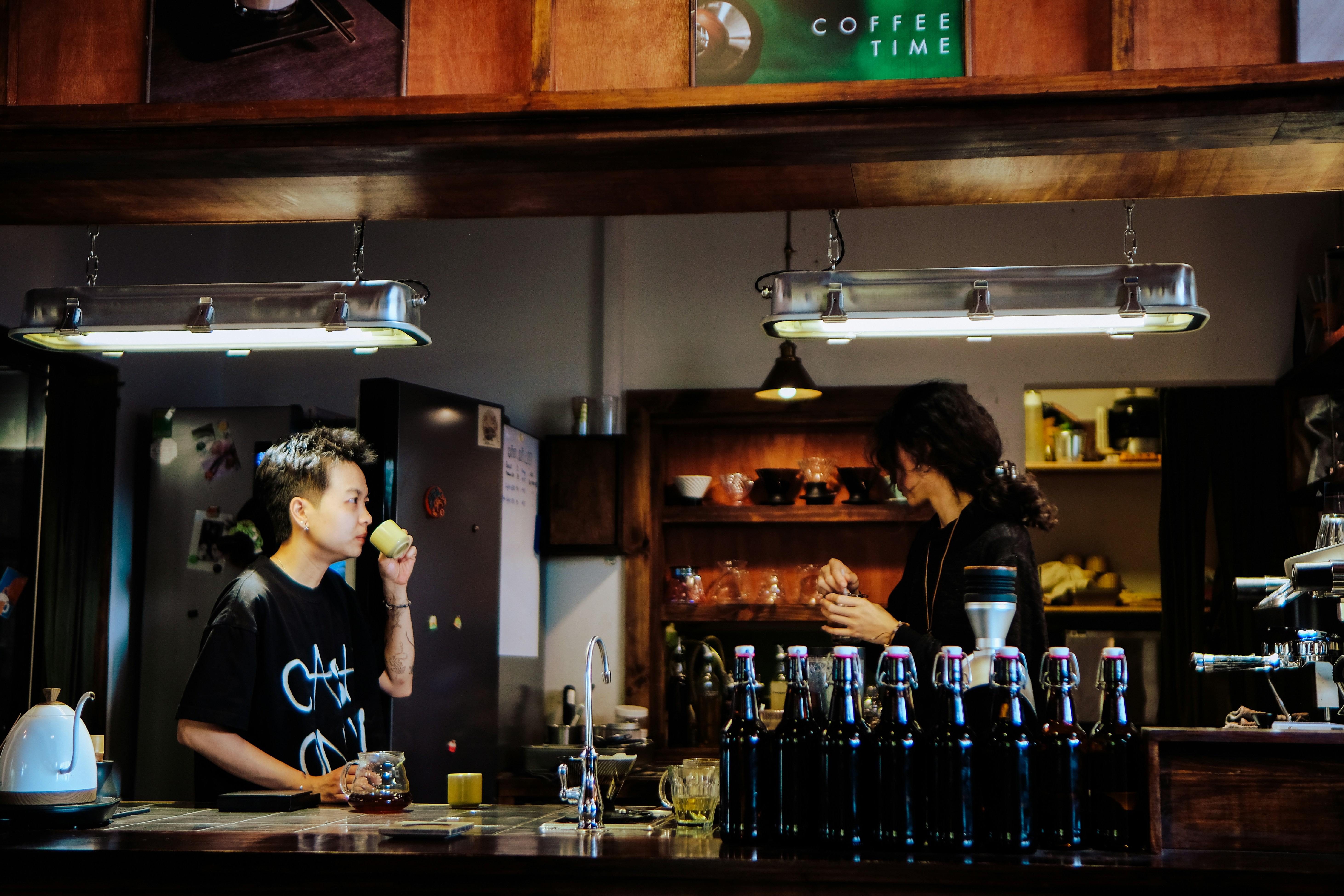 Quiet Bar Counter: A Man Sips as the Barista Prepares