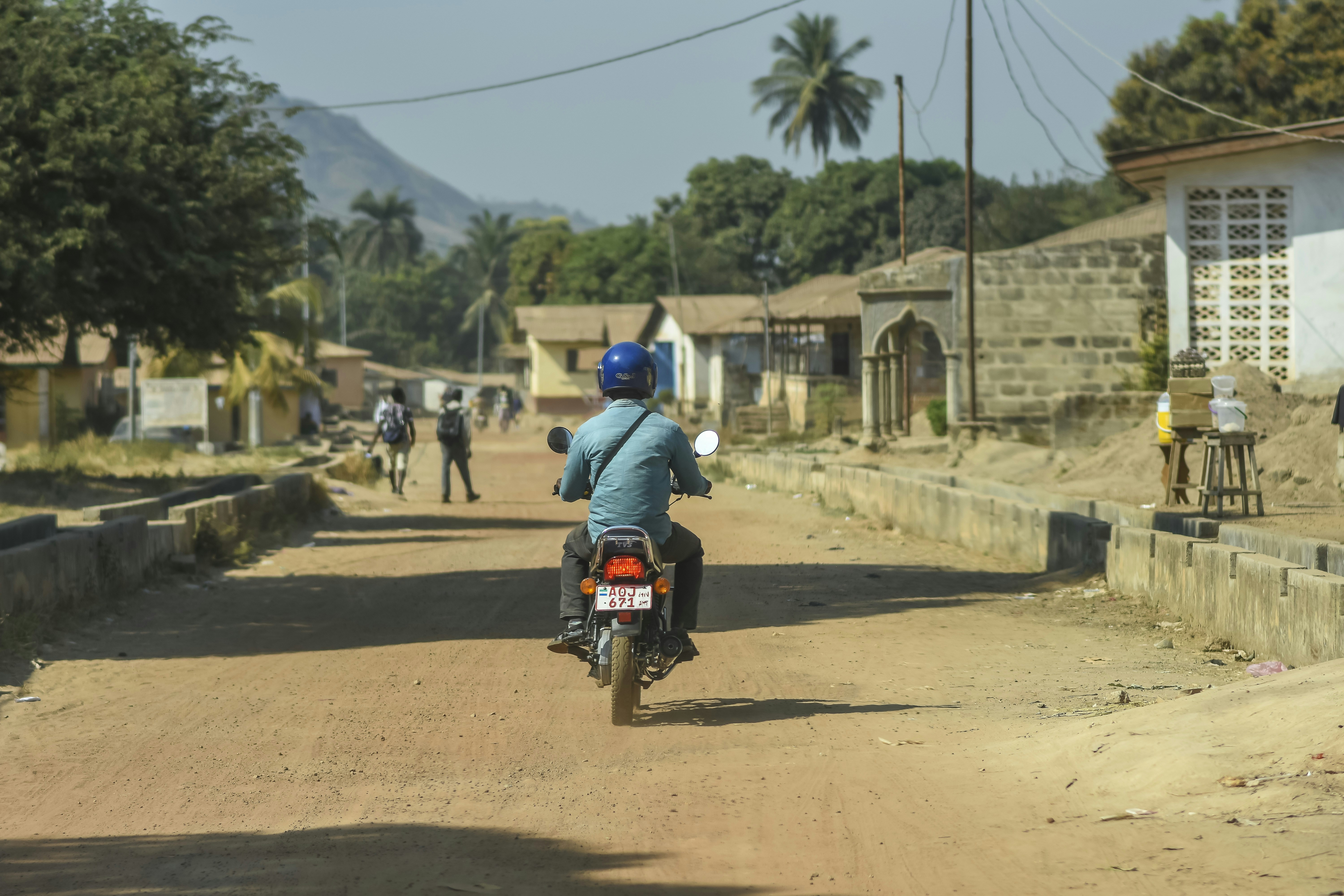 Rear-view Rider in a Dusty Village Road