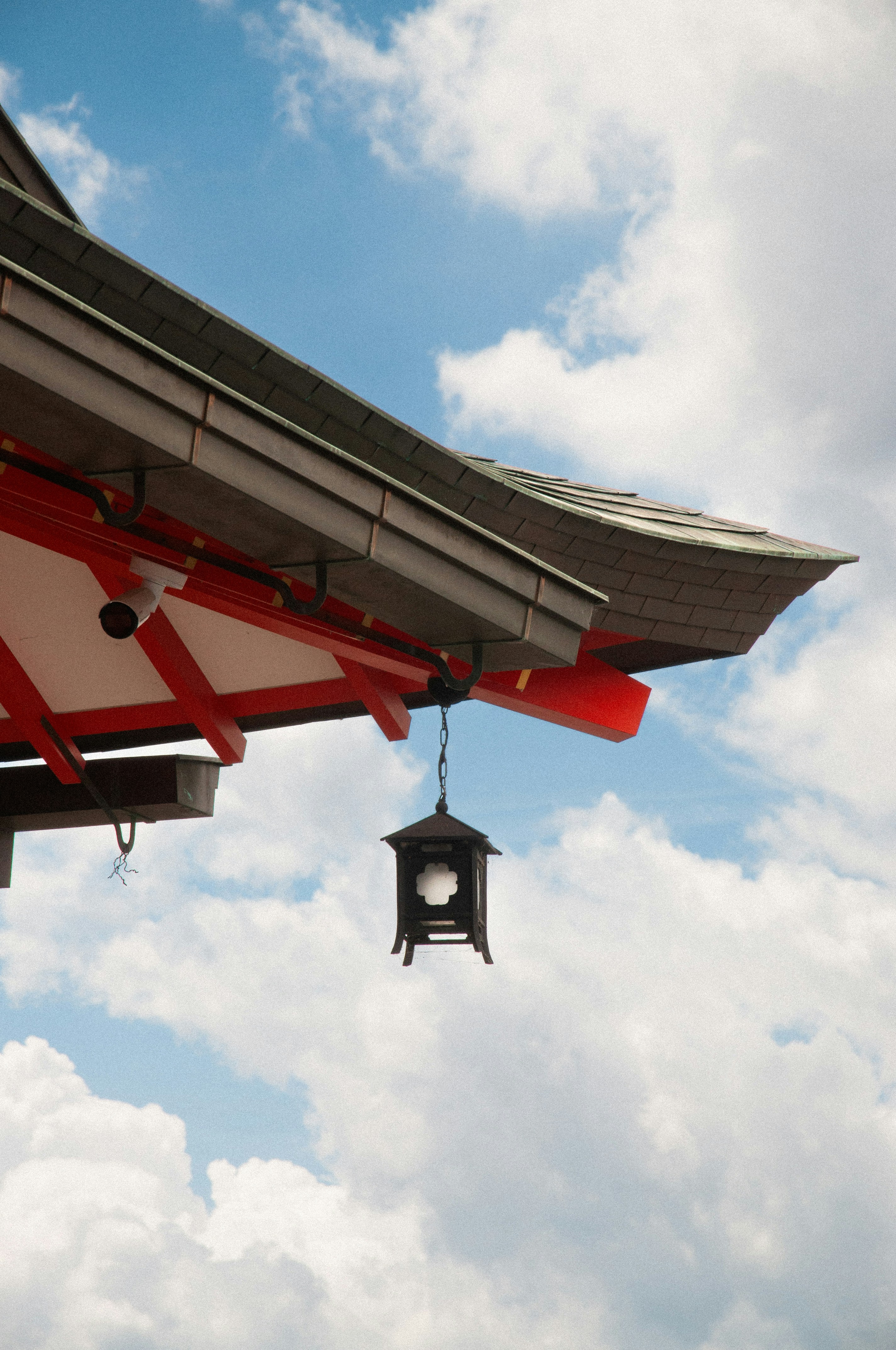 Lantern in Flight: A Roofline Under a Cerulean Sky