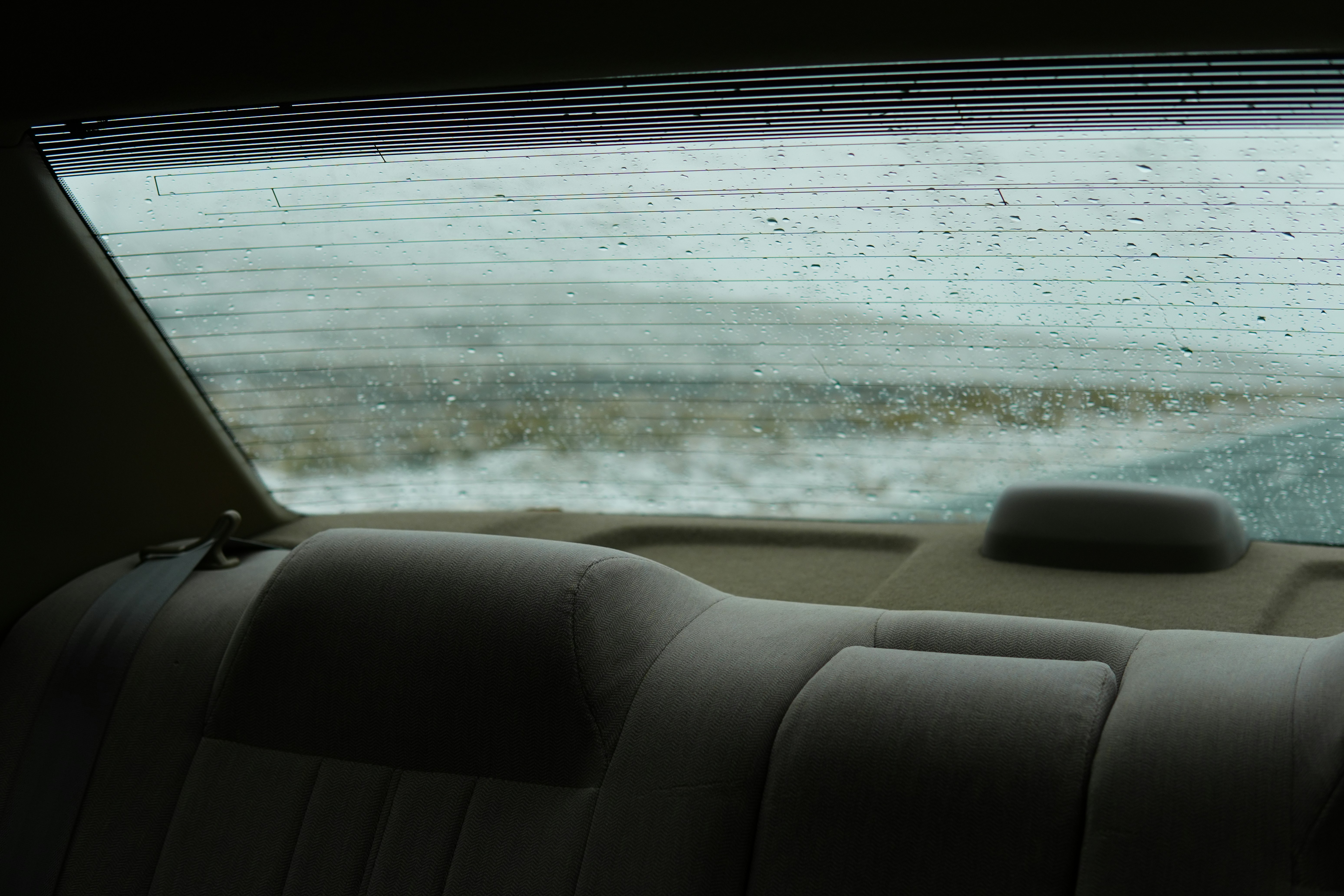 Rear Window Vision: Rain-Streaked Drive Through the Quiet Car