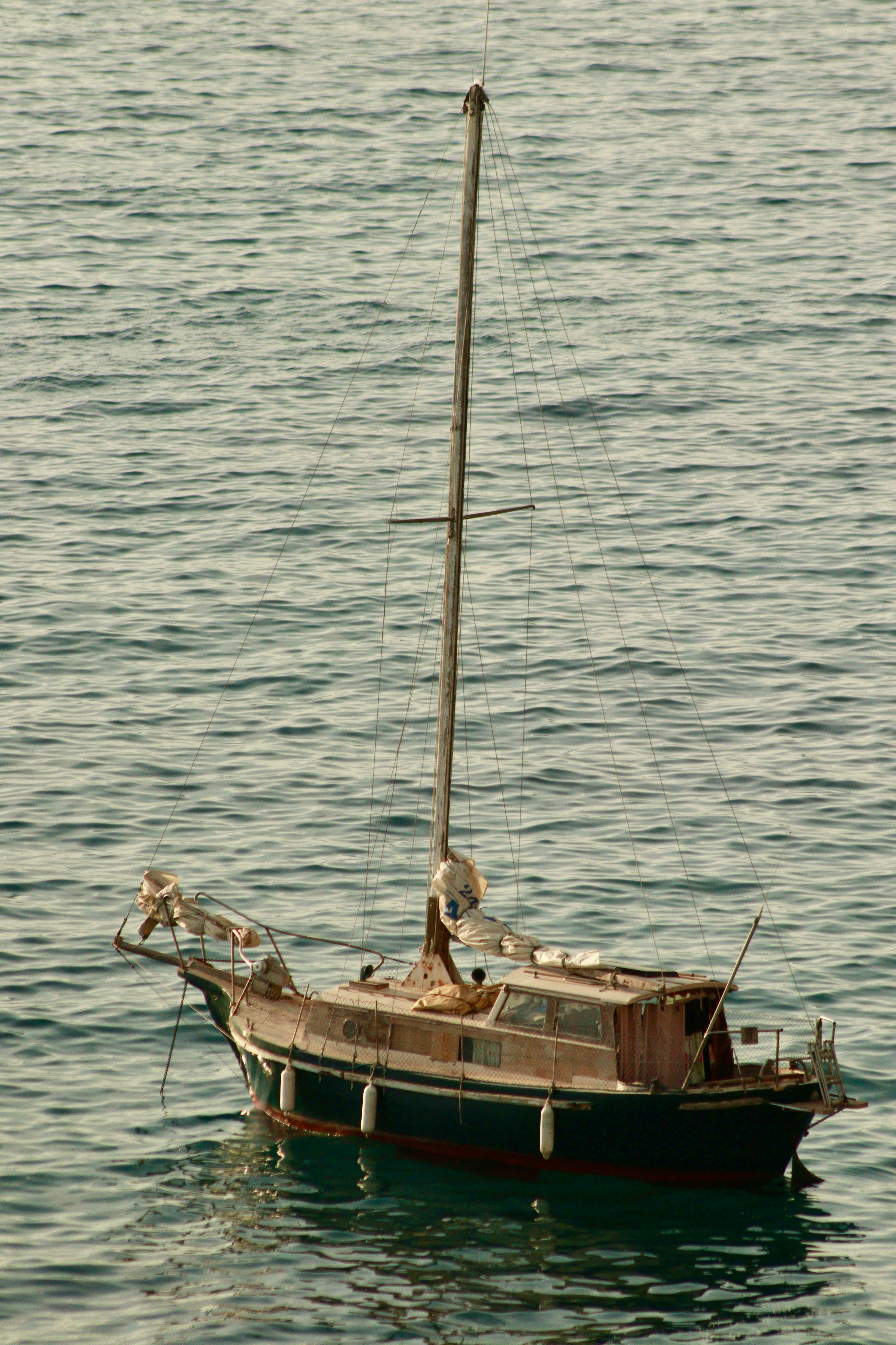  Sailing Vessel Drift: A Weathered Schooner Anchored in Quiet Blue