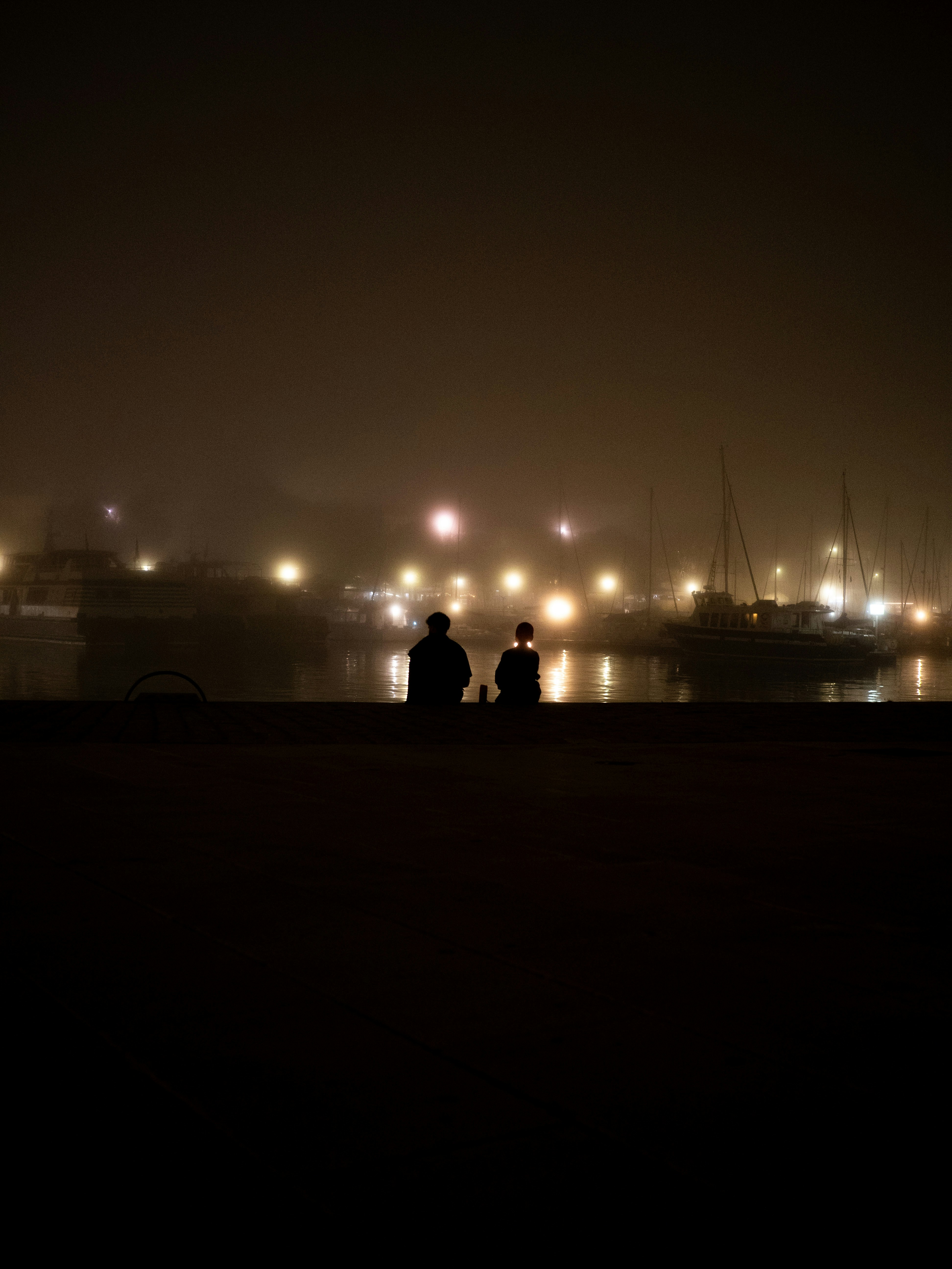 Two Silhouettes by the Fogged Quay