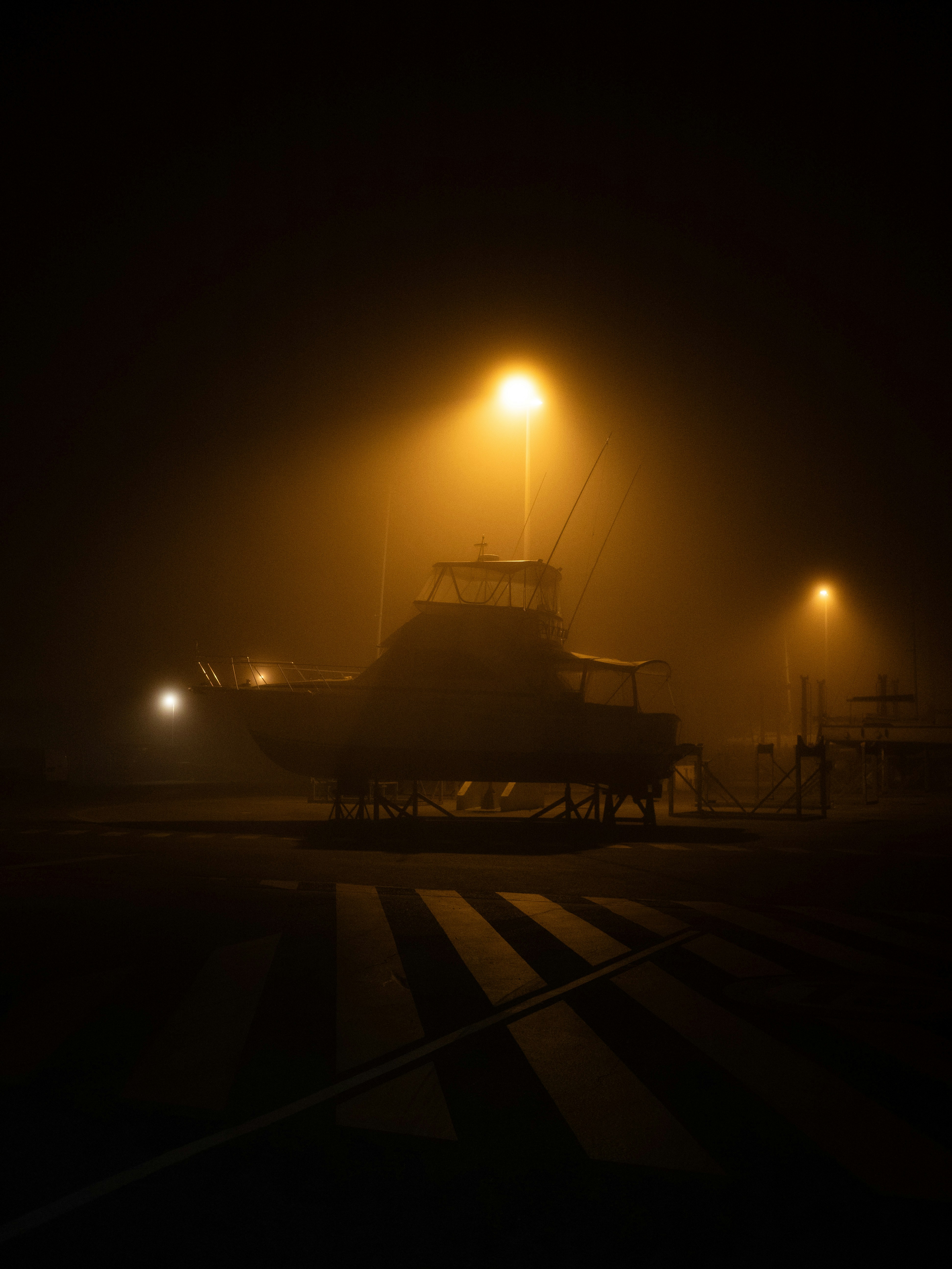 Midnight Harbor: A Vessel Silhouetted by Fog and Streetlight Orbs