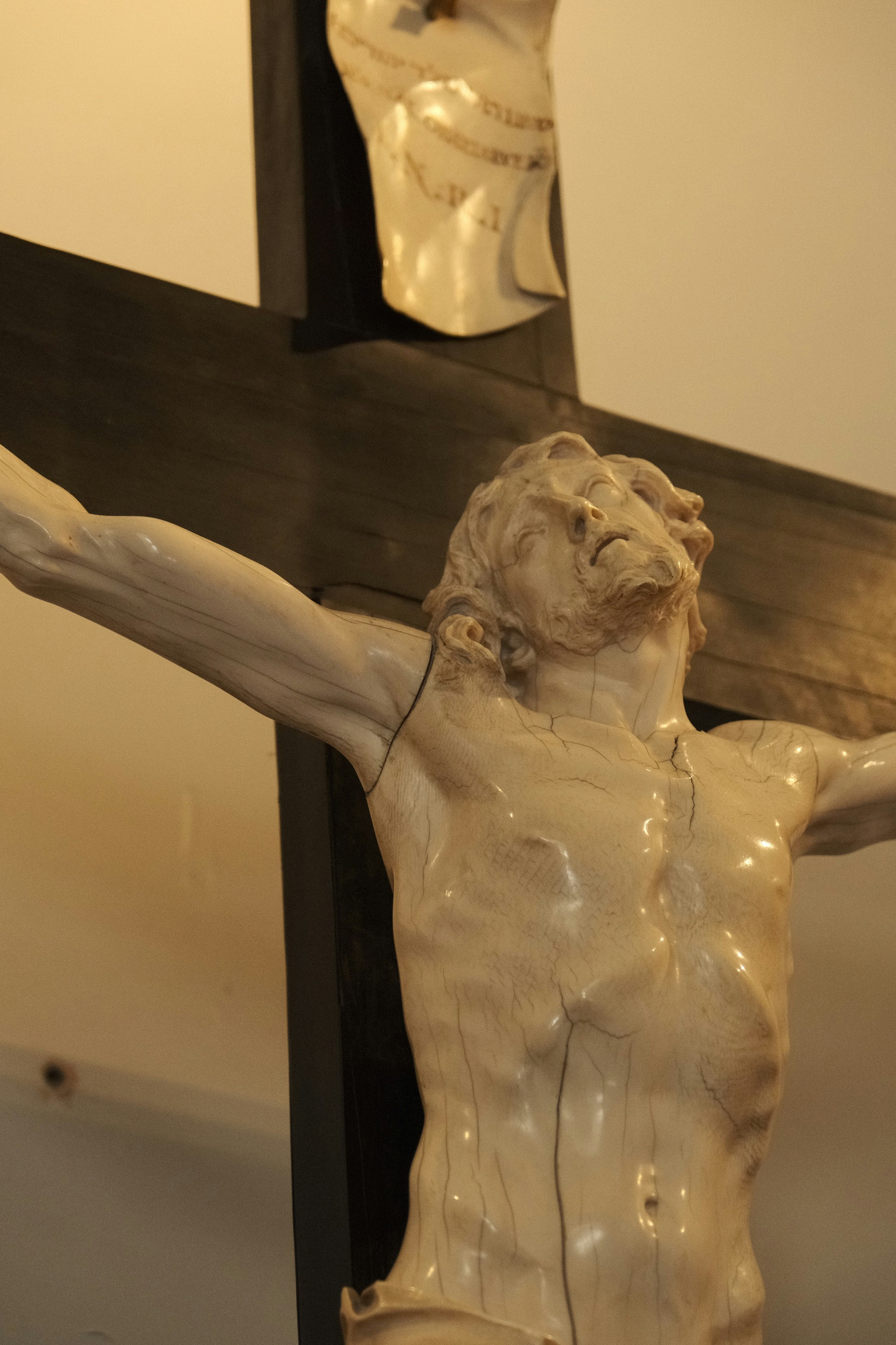 Crucifixion Figure: A Marble-Caped Silhouette in Warm Studio Light