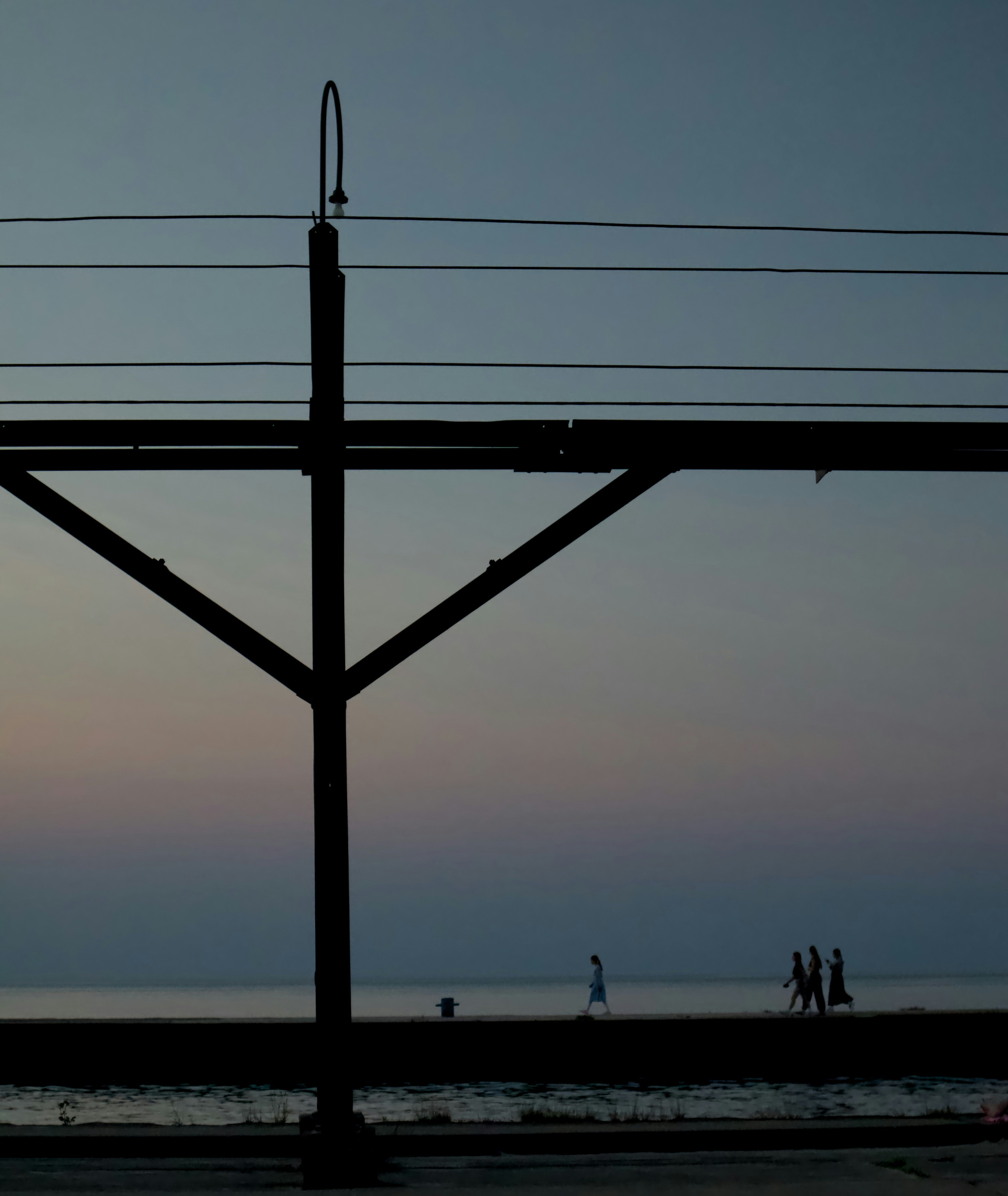 Silhouetted Pier Structure Against a Sunset Horizon