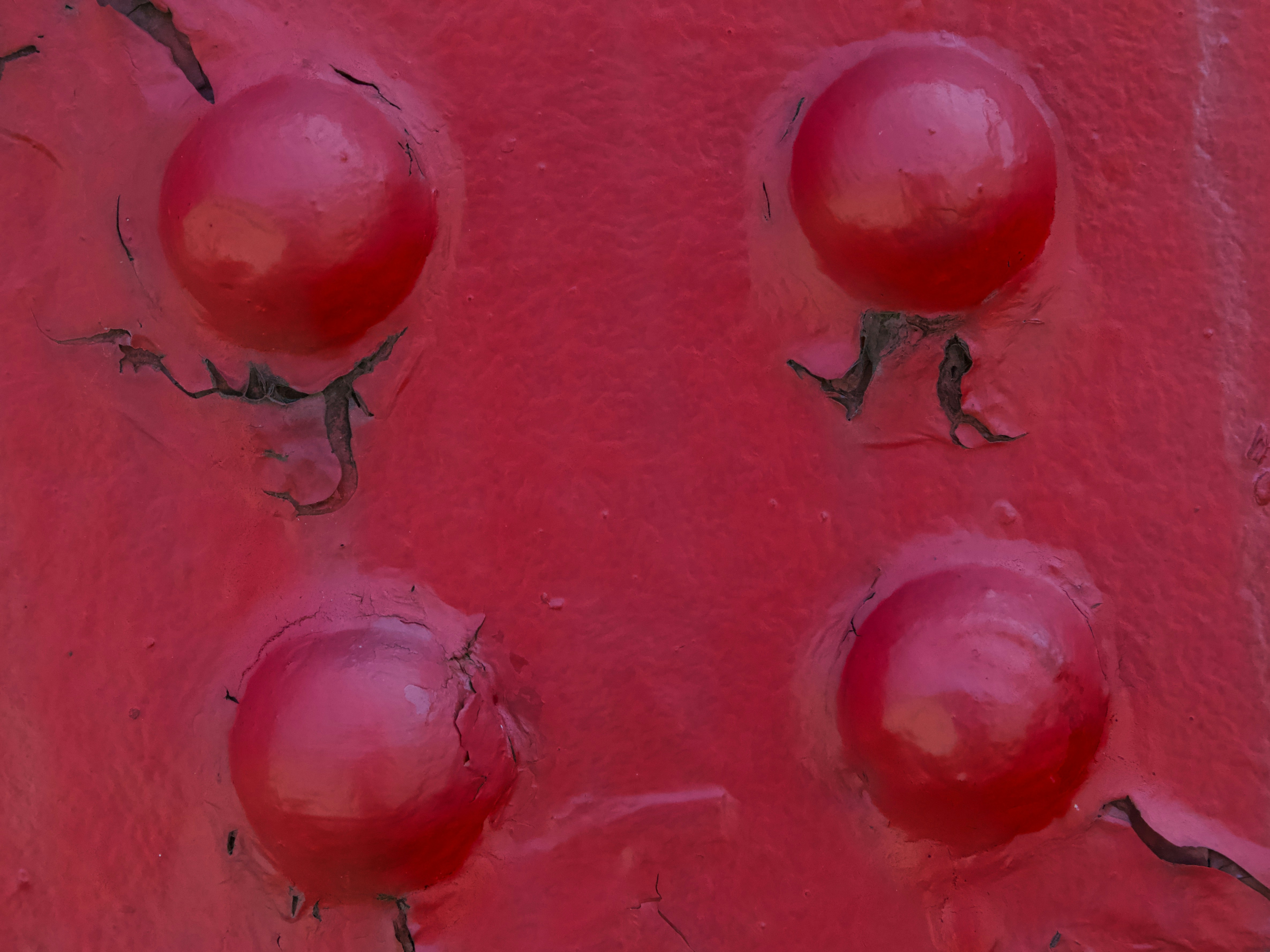 Riveted Red: Close‑up of riveted metal in bold scarlet
