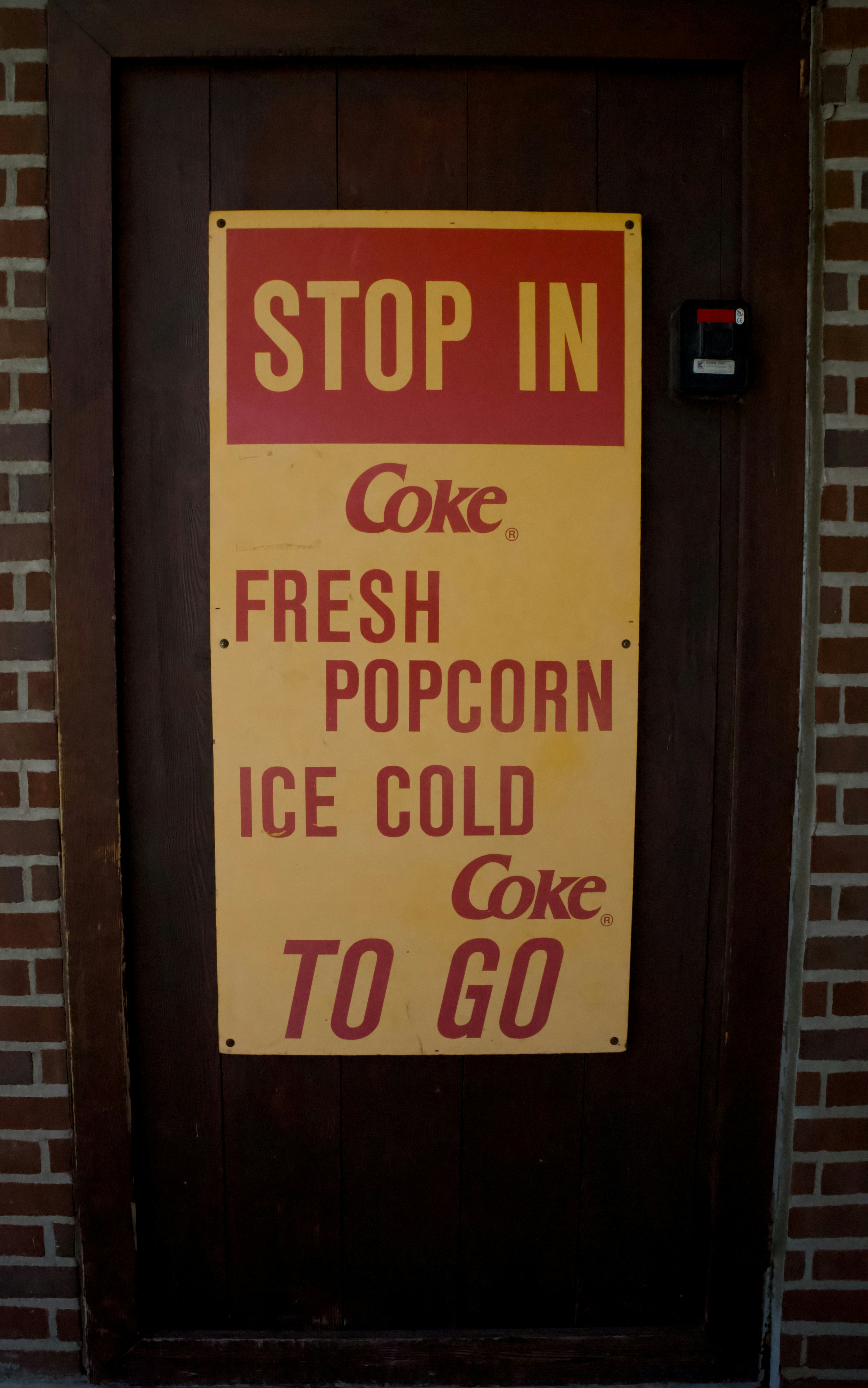 Signboard Anatomy: A Vintage Coke Revelation on a Dark Door