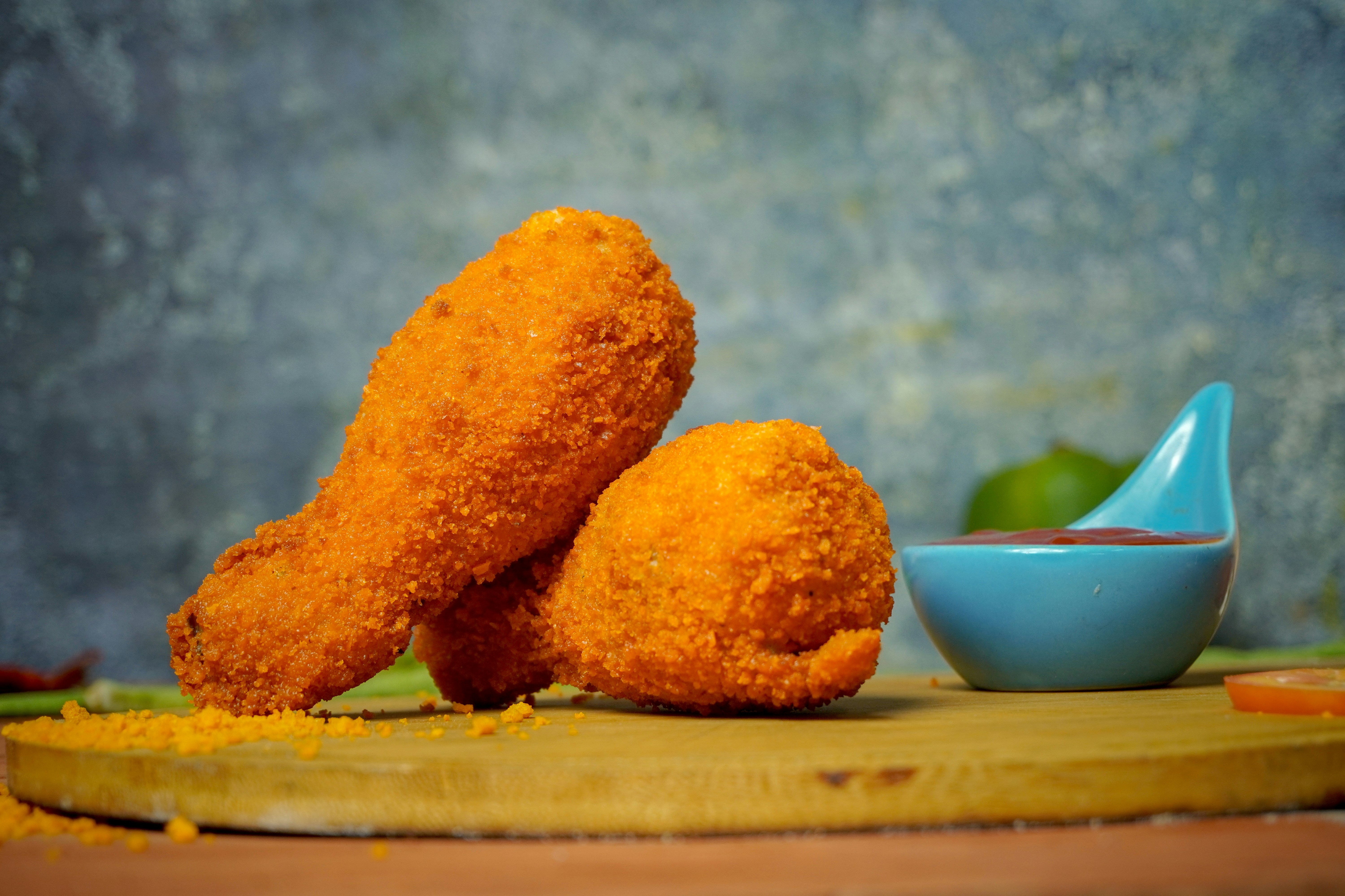 Crisped Golden Croquettes on a Wooden Board with Dipping Sauce