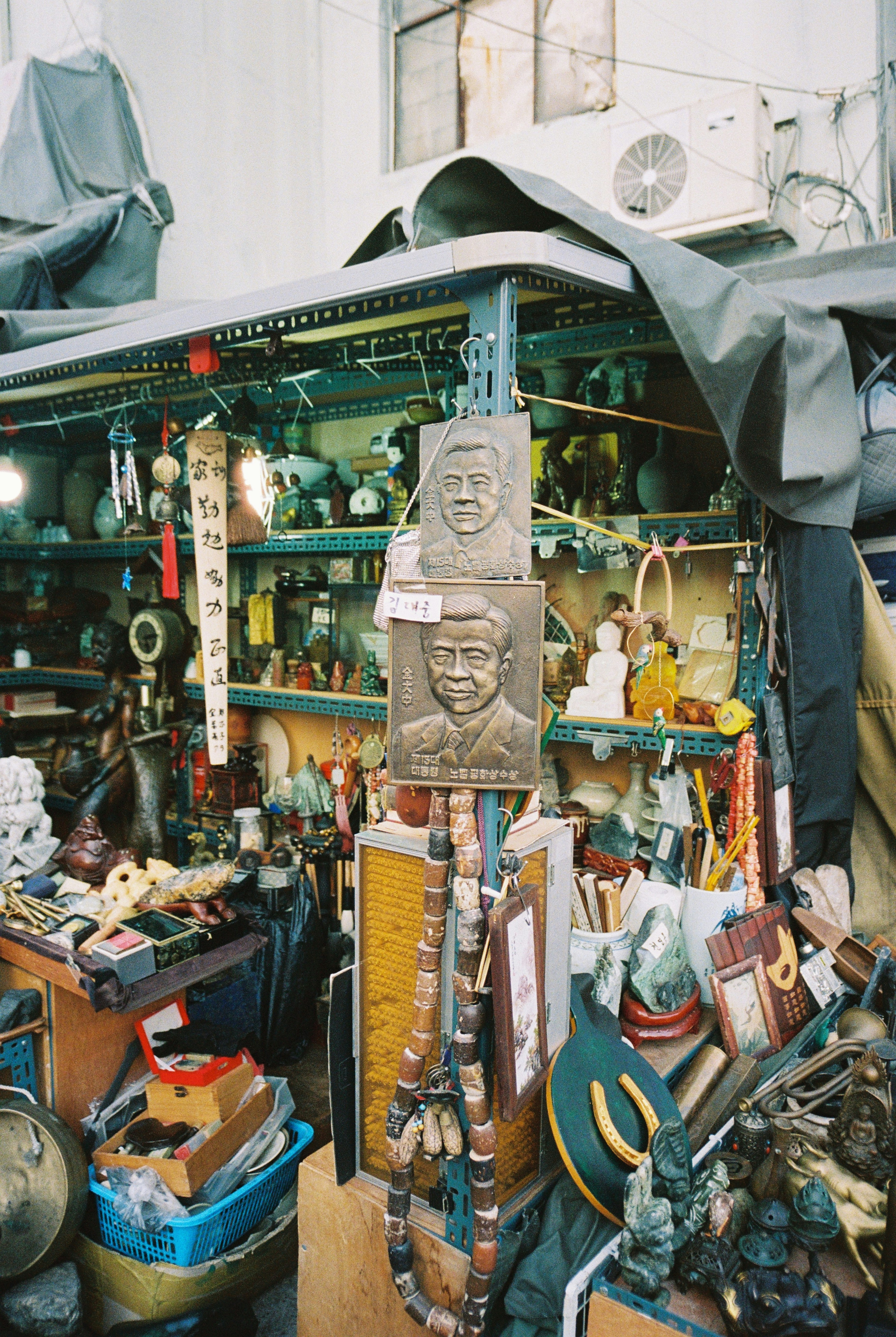 Entrance to a Treasure-Trove Stall: Faces and Trinkets Among the Clutter