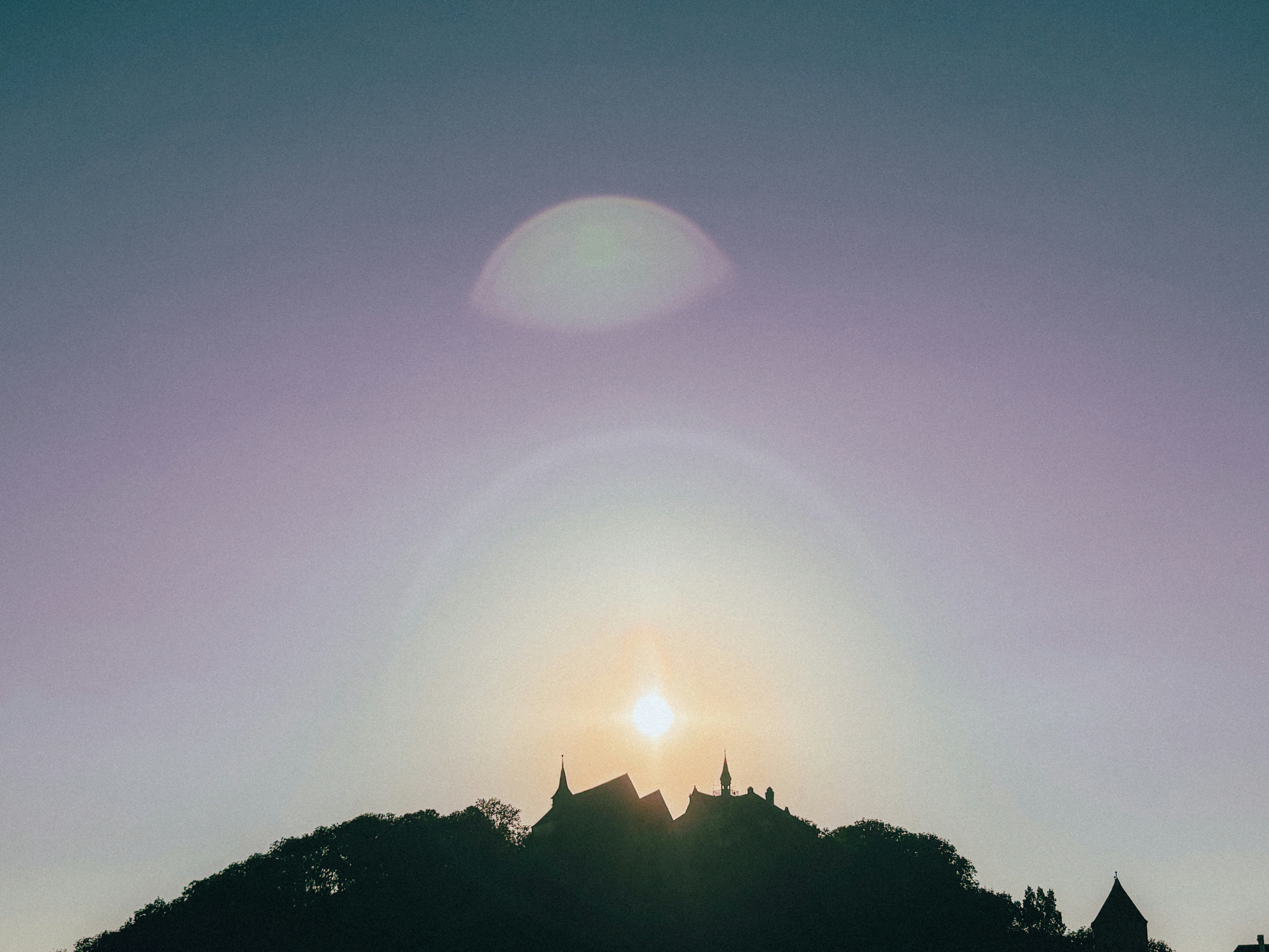 Silhouette of a Hilltop Castle Framed by a Radiant Halo