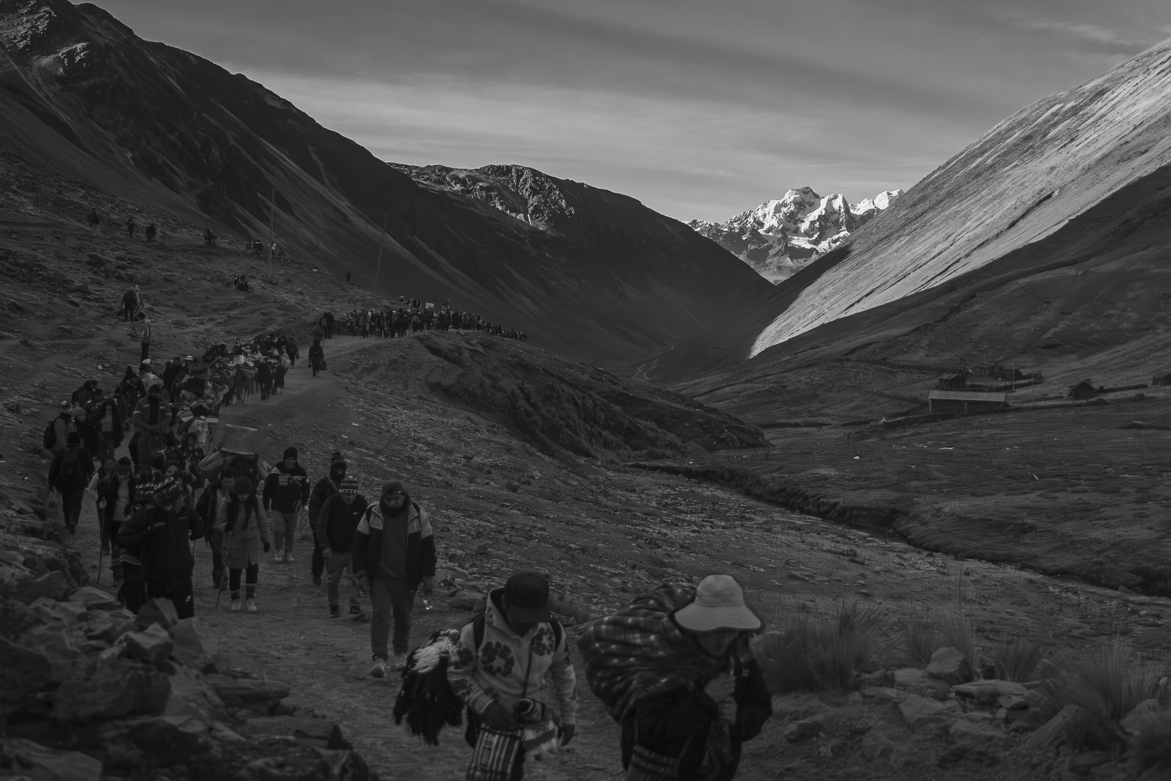 Caravan Ascent: A Line of Climbers Winding Toward Snowlit Peaks