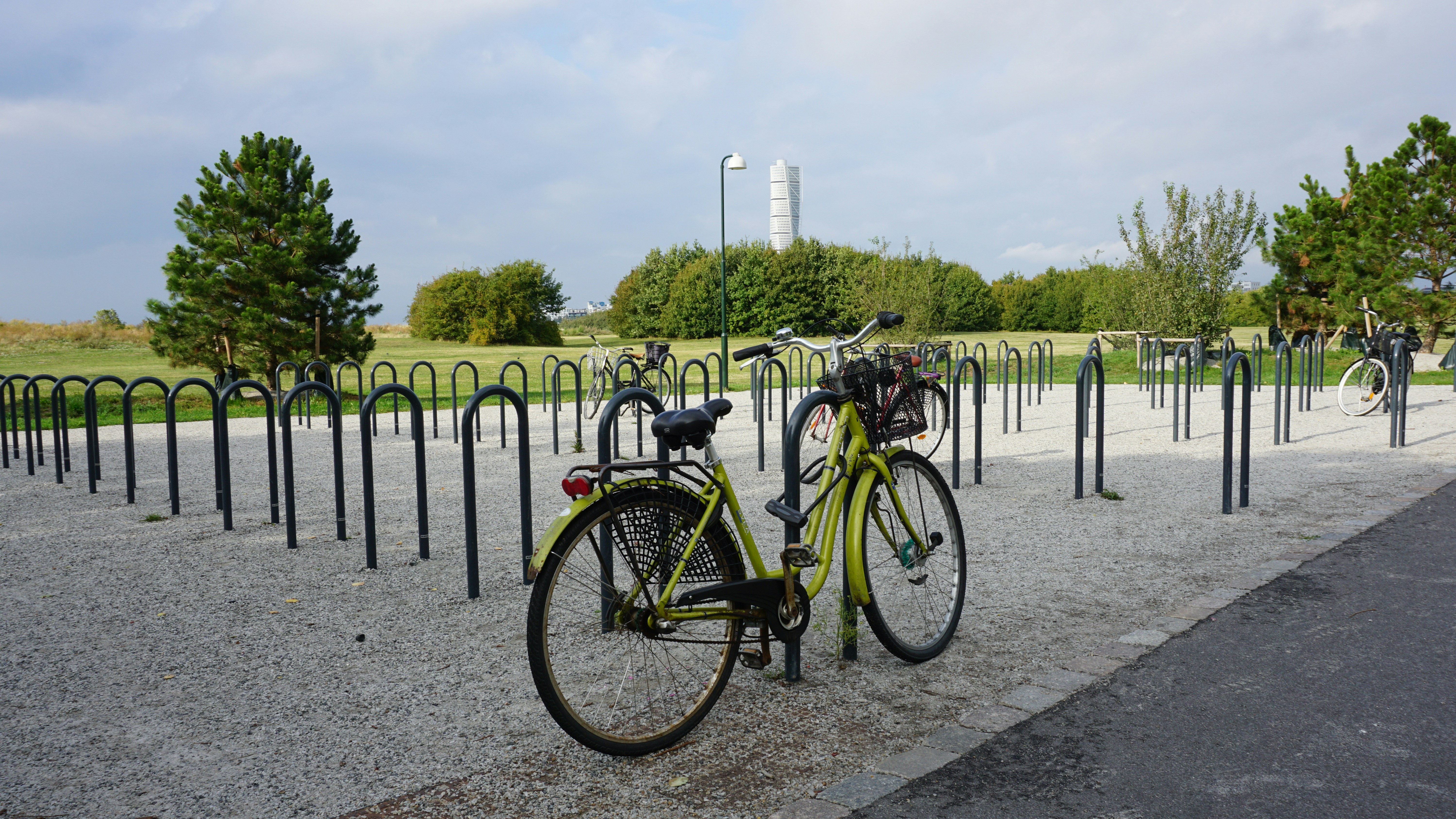 A lime-green bicycle at a modern bike rack landscape