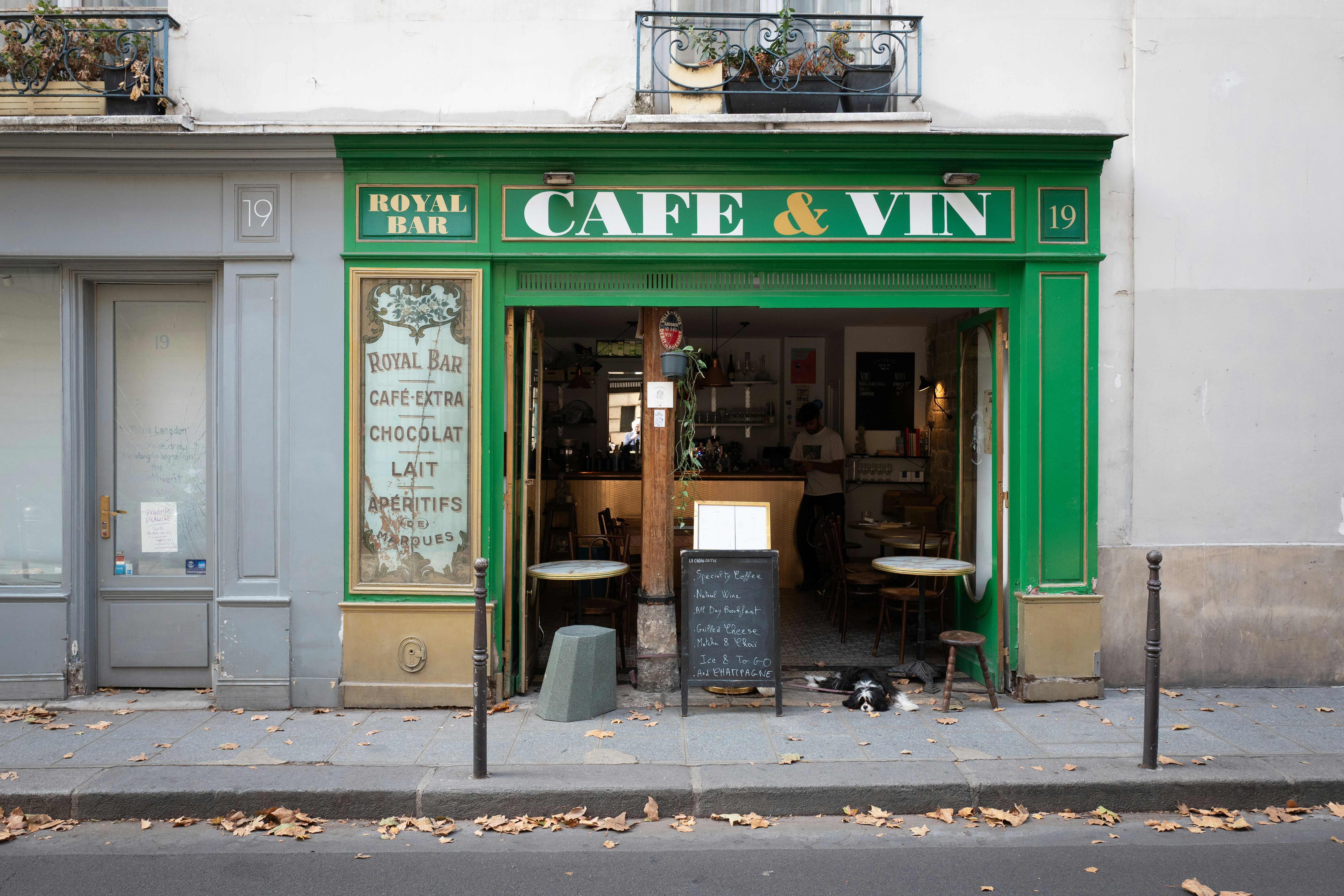 Green Café Doorway: A Quiet Parisian Corner with Waitstaff at Dawn