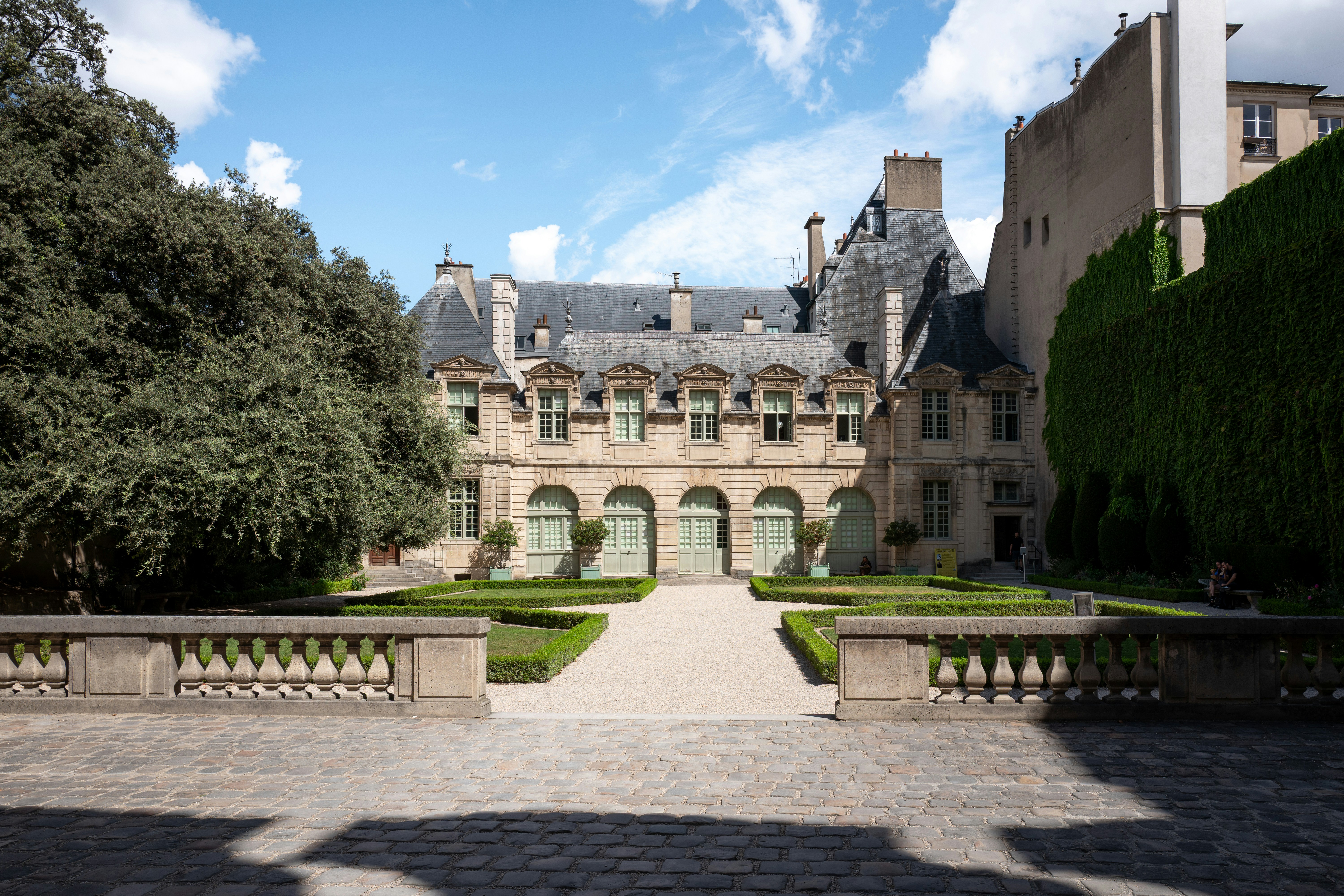 Symmetrical Manor: A Sunlit Courtyard Framing a Historic Facade
