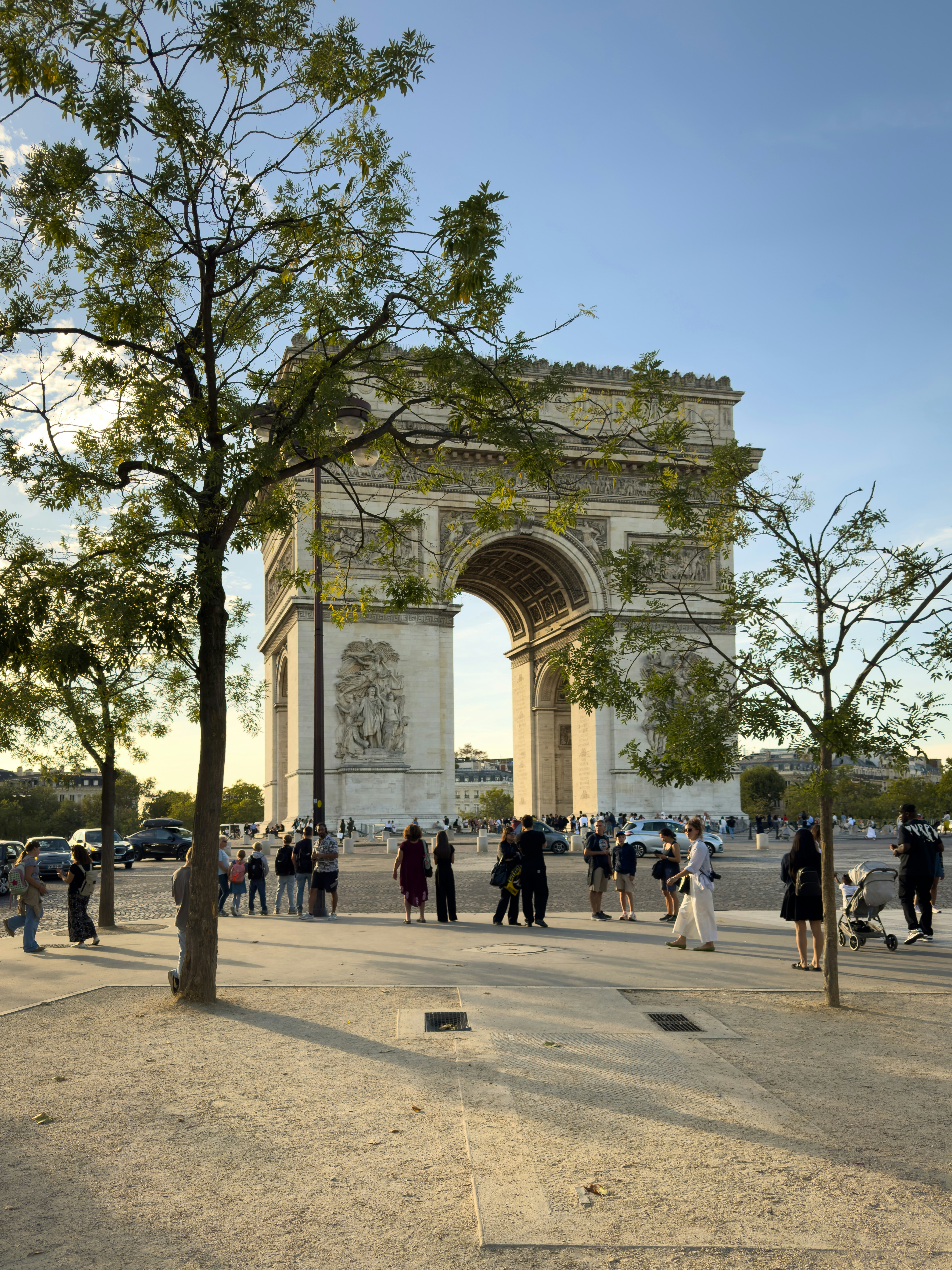 Arcade of Light: The Arc de Triomphe Framed by Dappled Shade