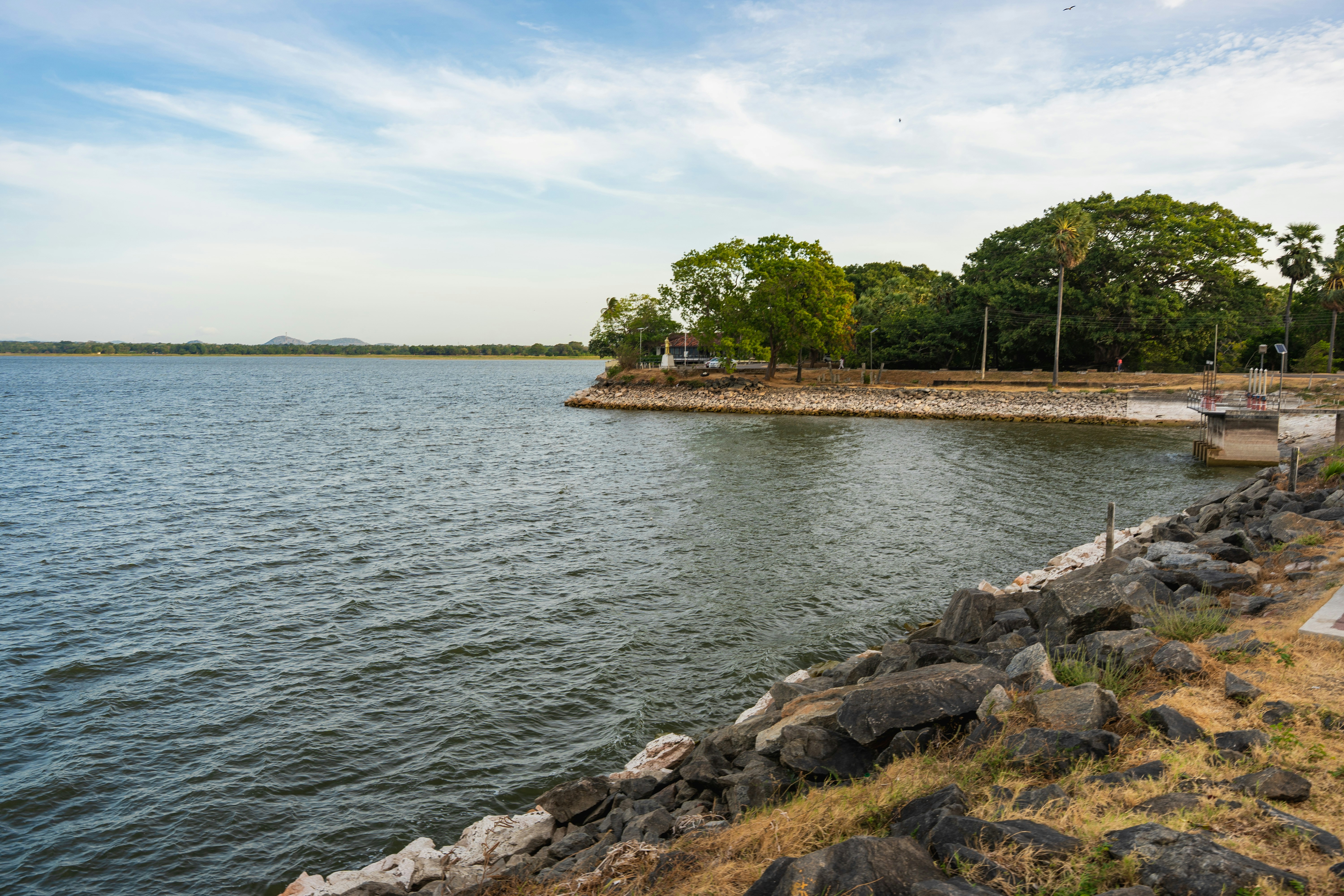 Lakeside Calm: A Rocky Promenade by the Quiet Bay