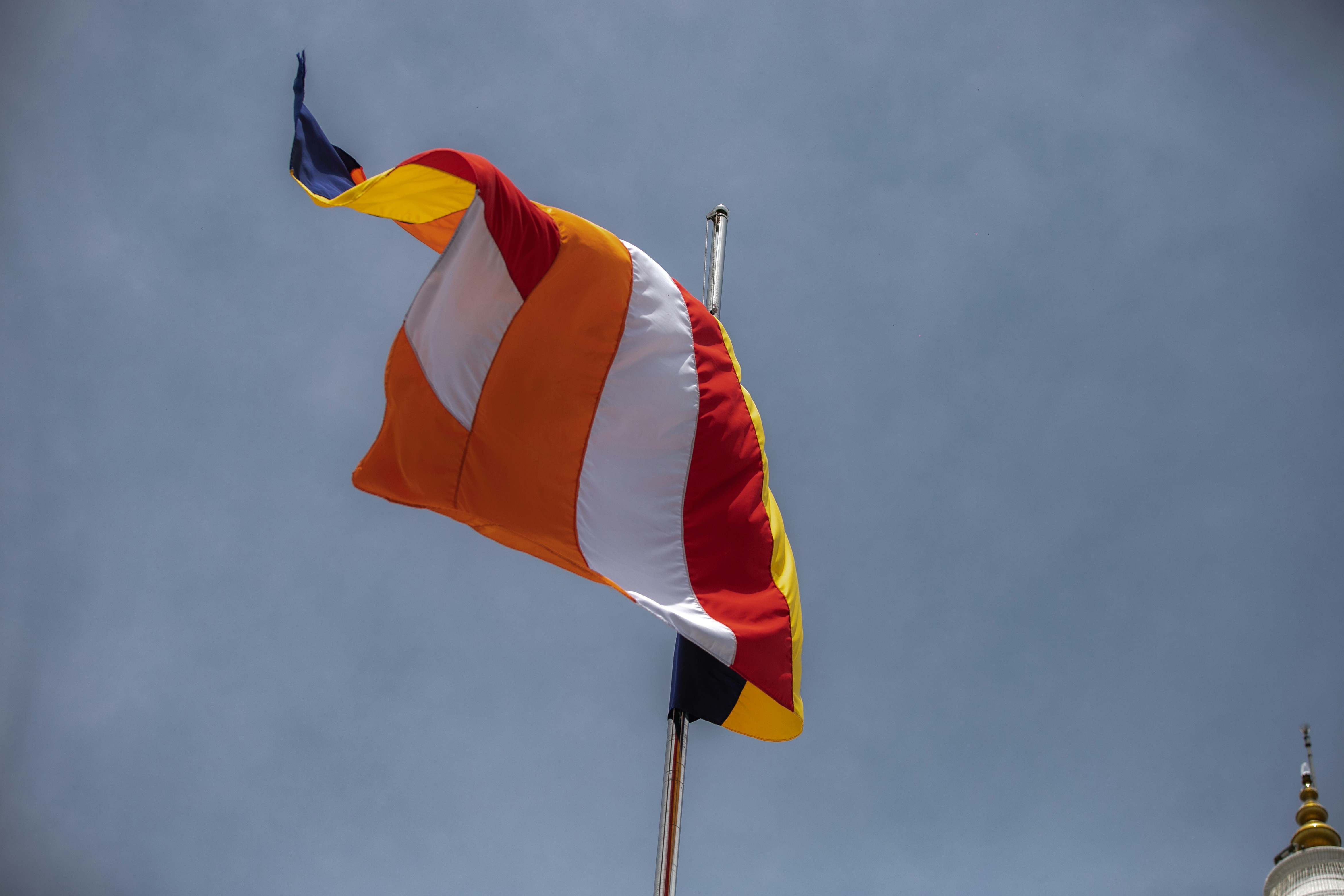 Flag in the Breeze: A Multicolor Banner Against a Clear Sky