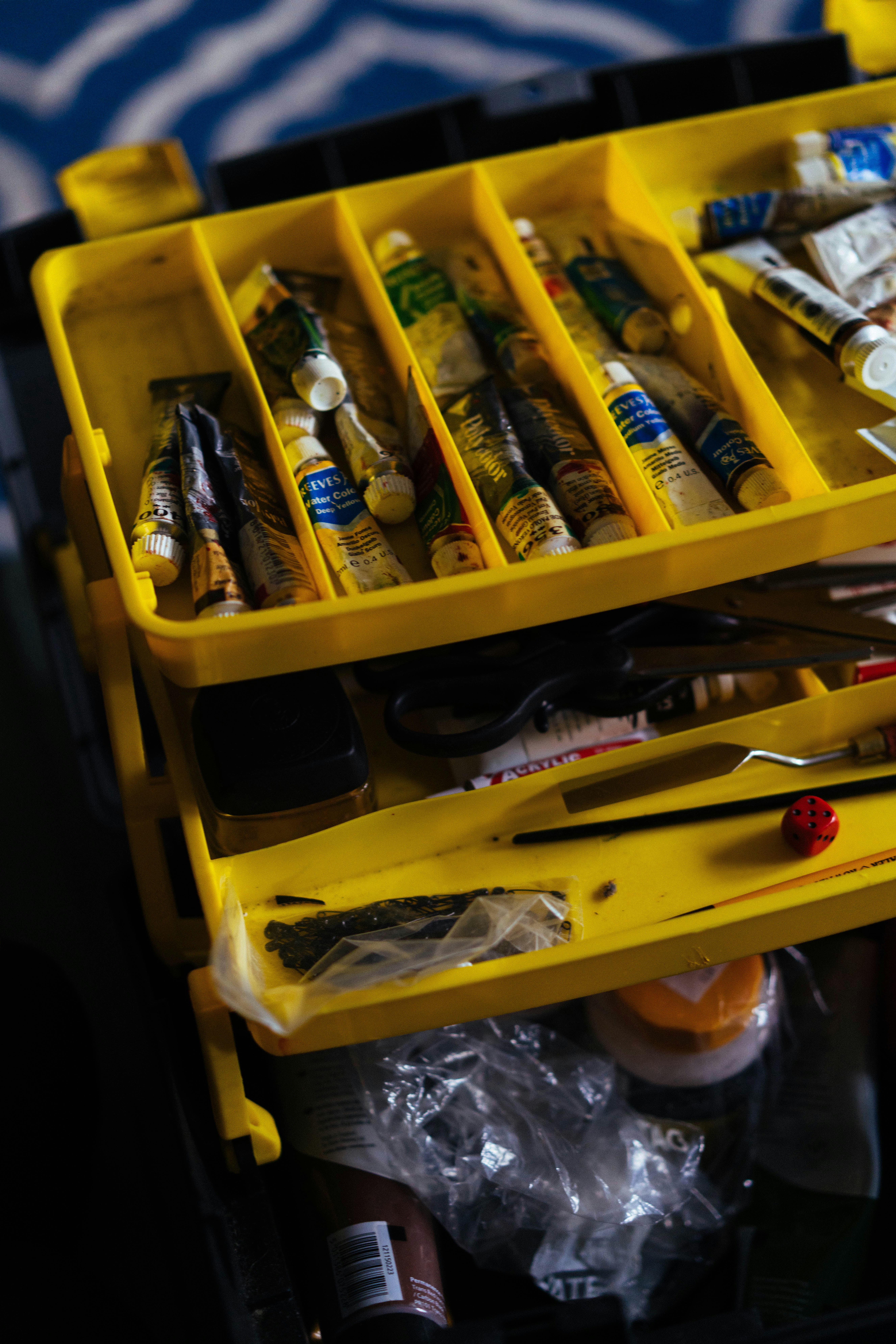 Yellow toolbox drawers of paint tubes and tools