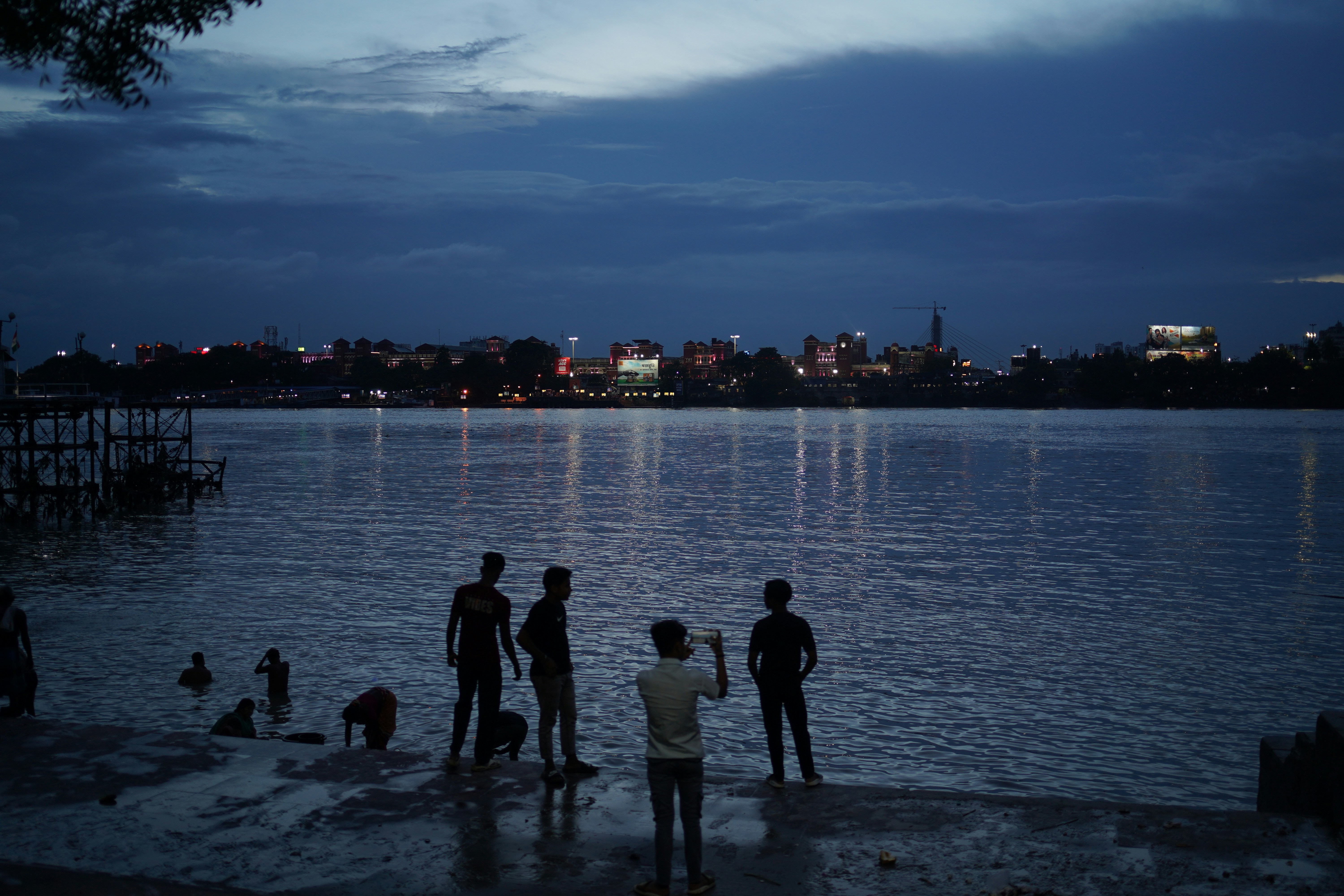 Silhouetted Children at the Shore Under a Dusk Blue Sky