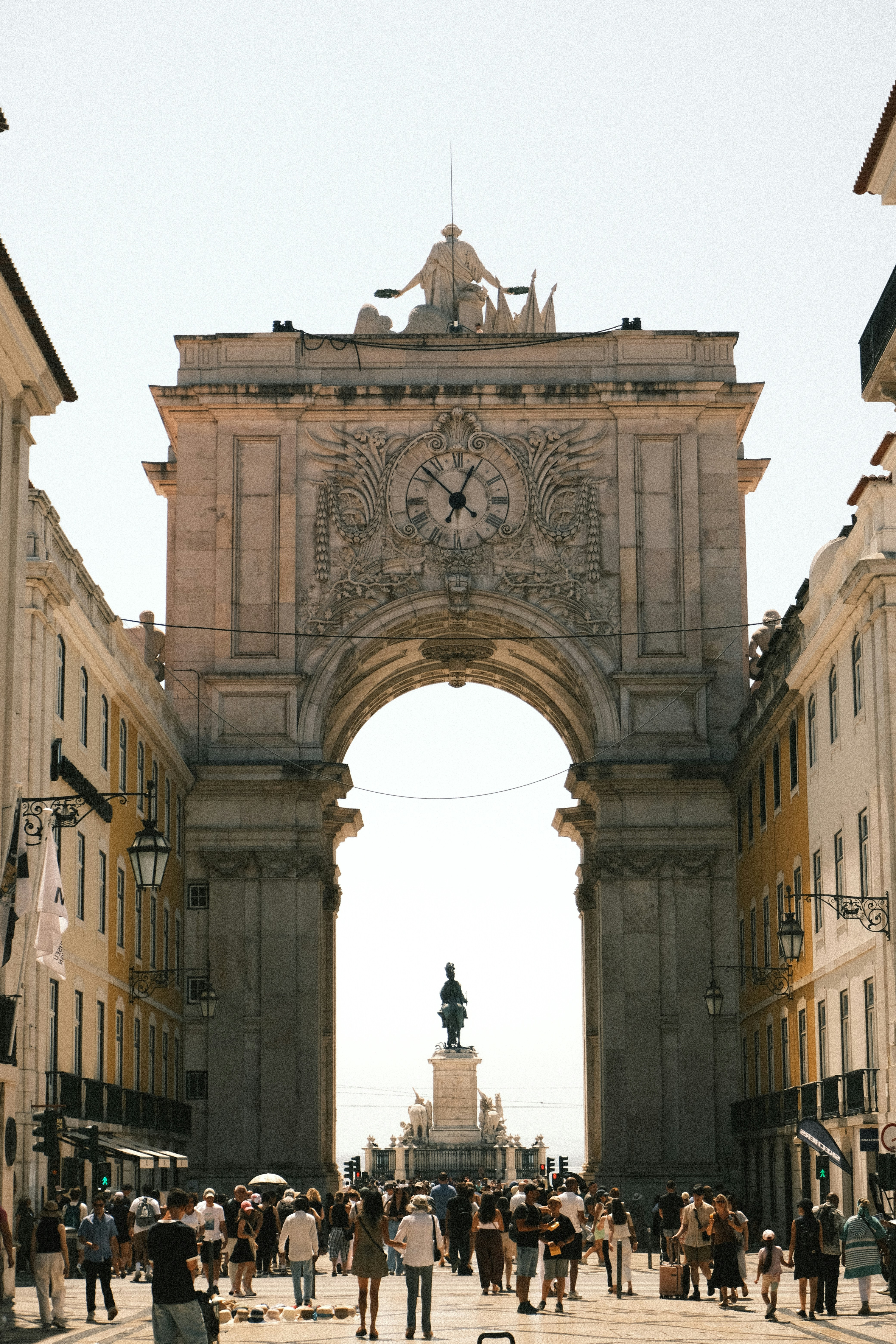 Archway of Time: A Sunlit Praça Framed by a Crowd