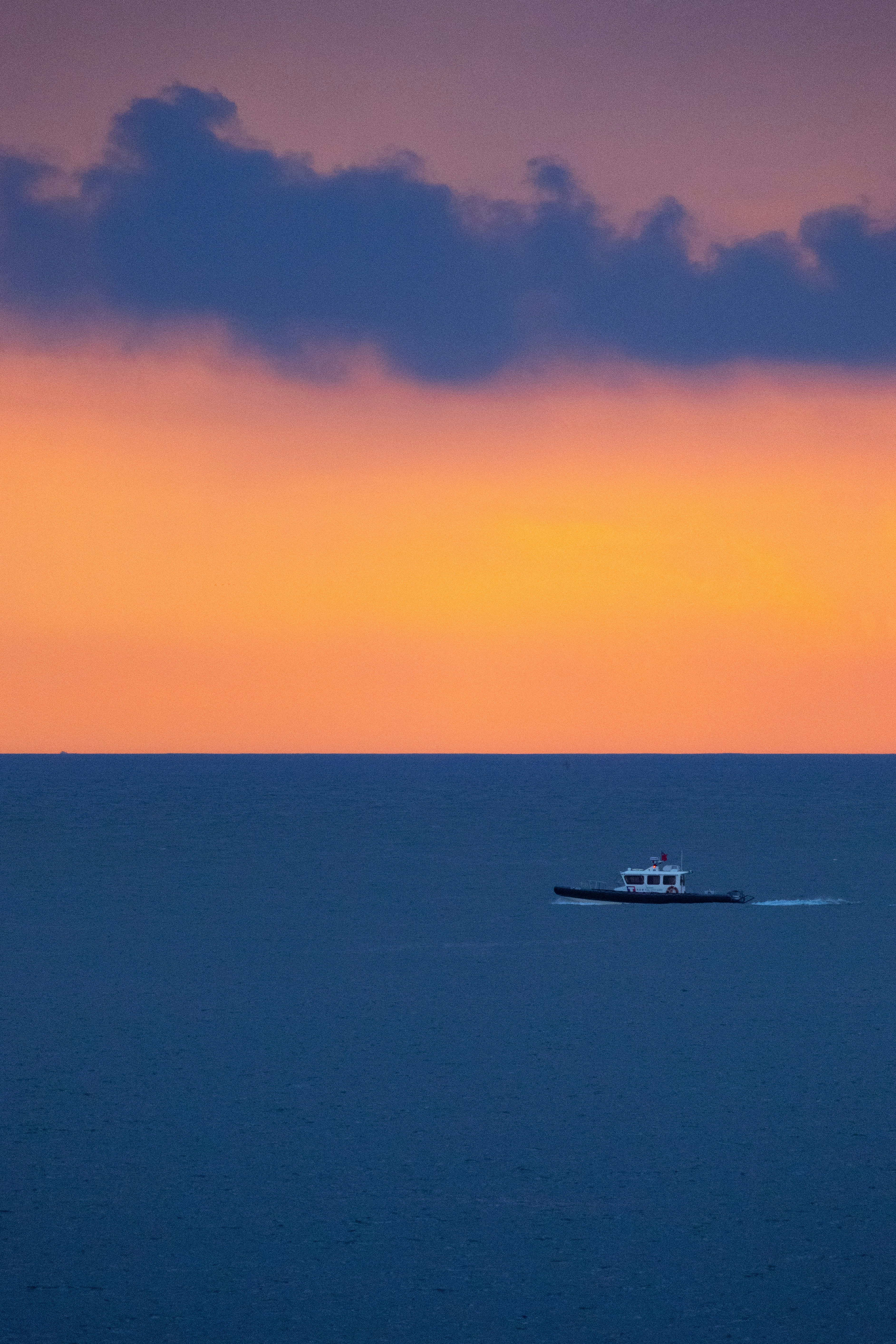 Lone Boat Crossing the Colorwash Horizon at Dusk