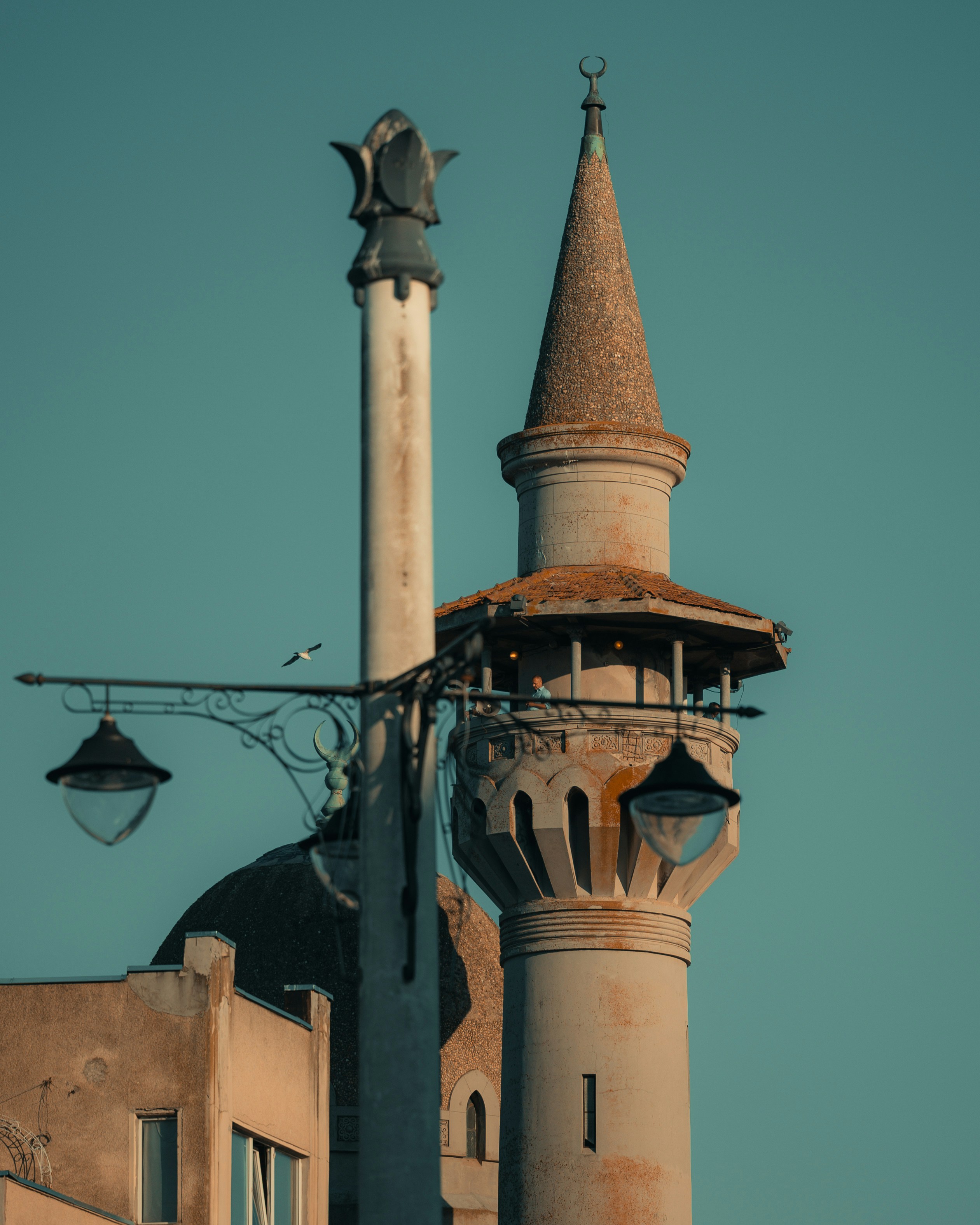Turret and Lanterns: Sunlit Corner of a Historic Street Minaret