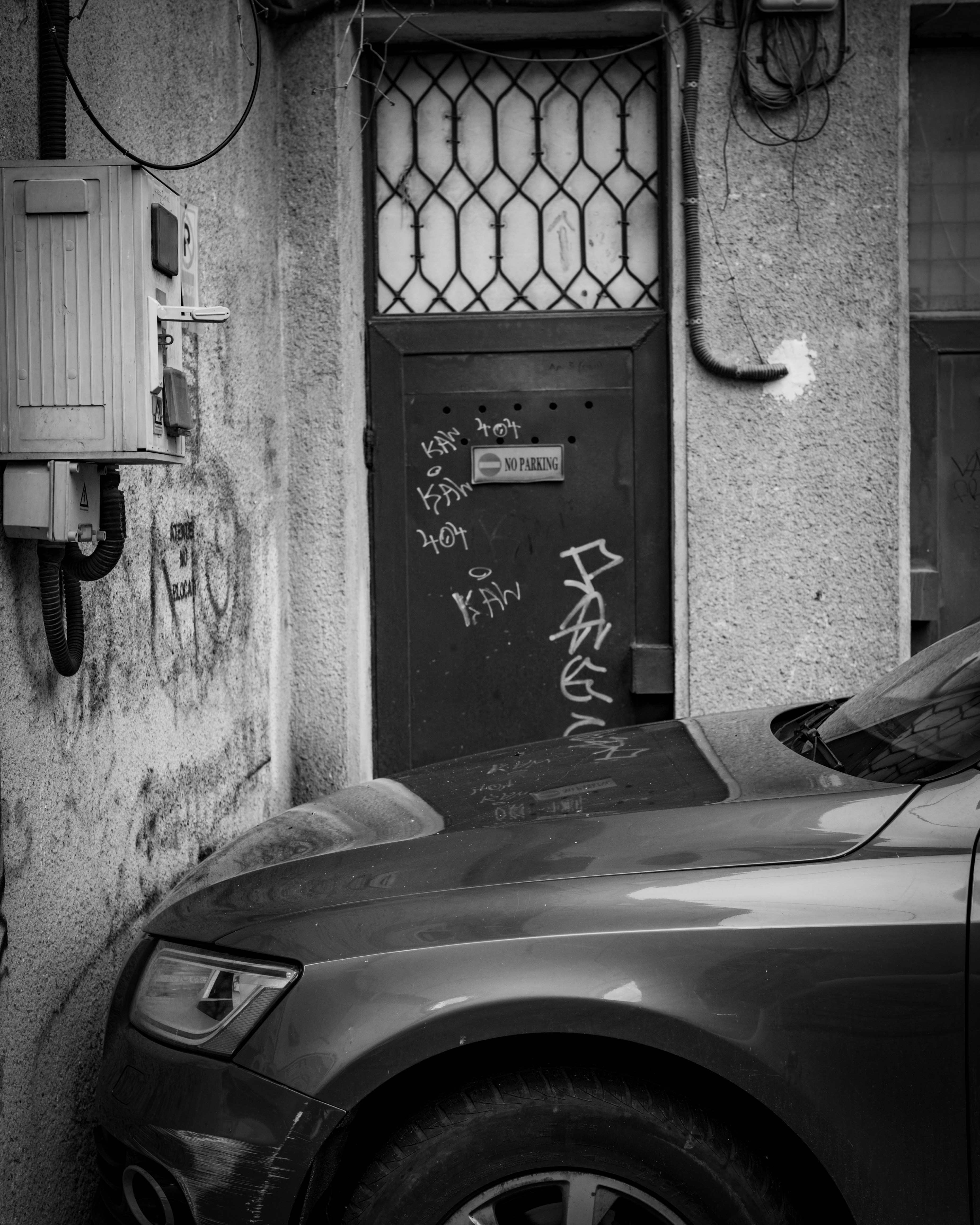Graffiti Gate and Car Edge in a Dappled Urban Facade