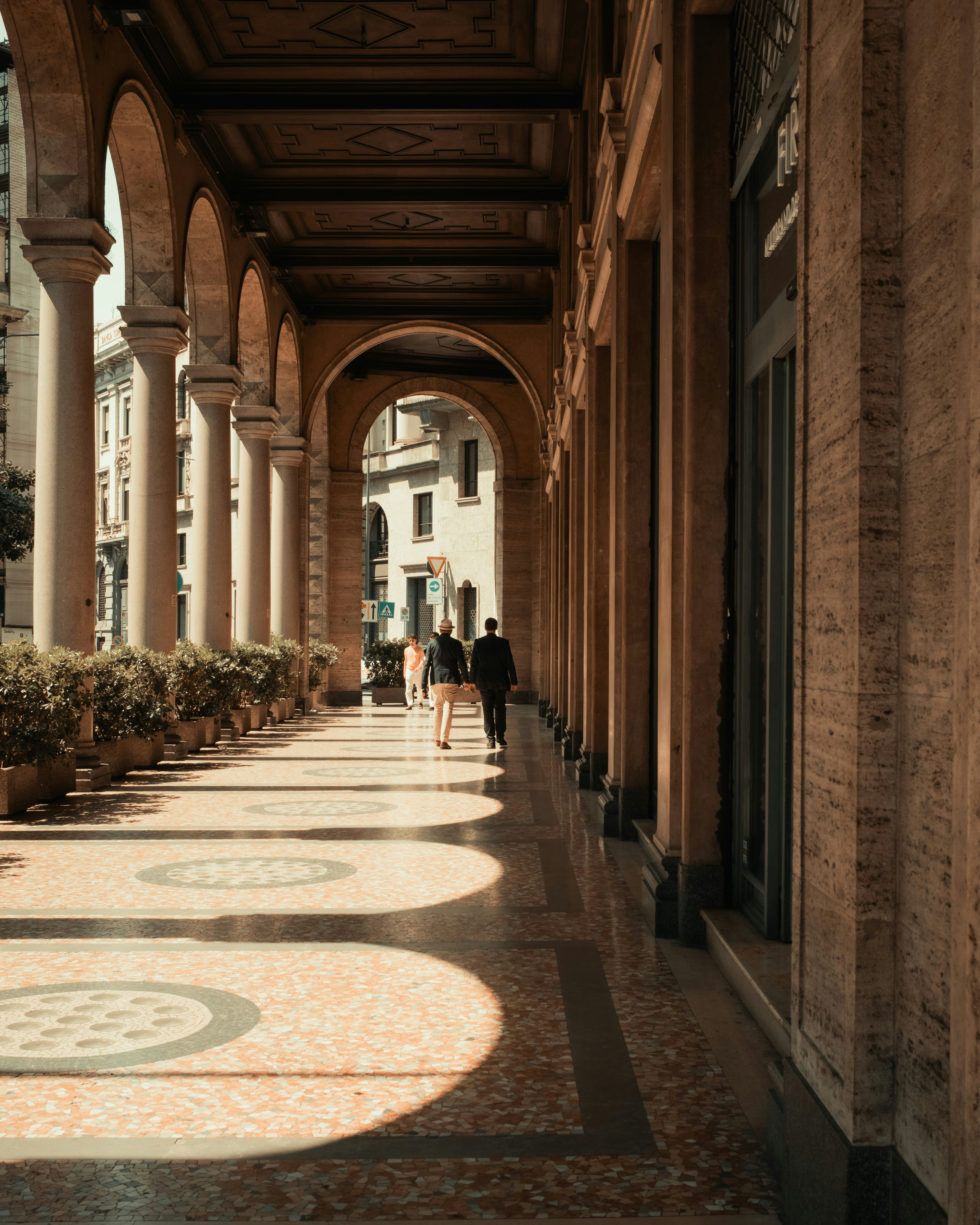 Sunlit Arcade Echoes: Arched Colonnades and a Walk Toward the Vanishing Light