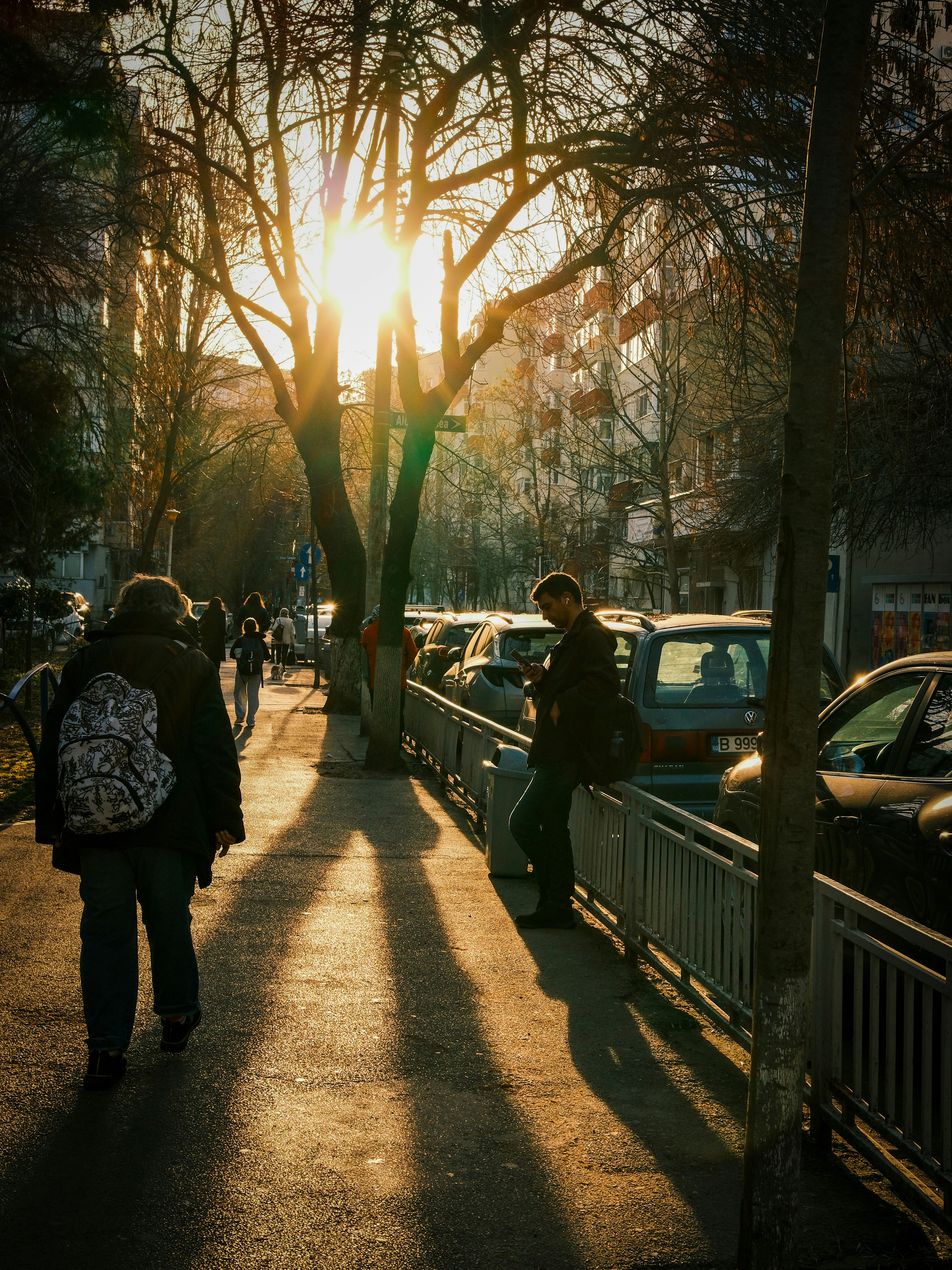 Sunlit Sidewalk Chase: Shadows and Silhouettes Along a Busy Street