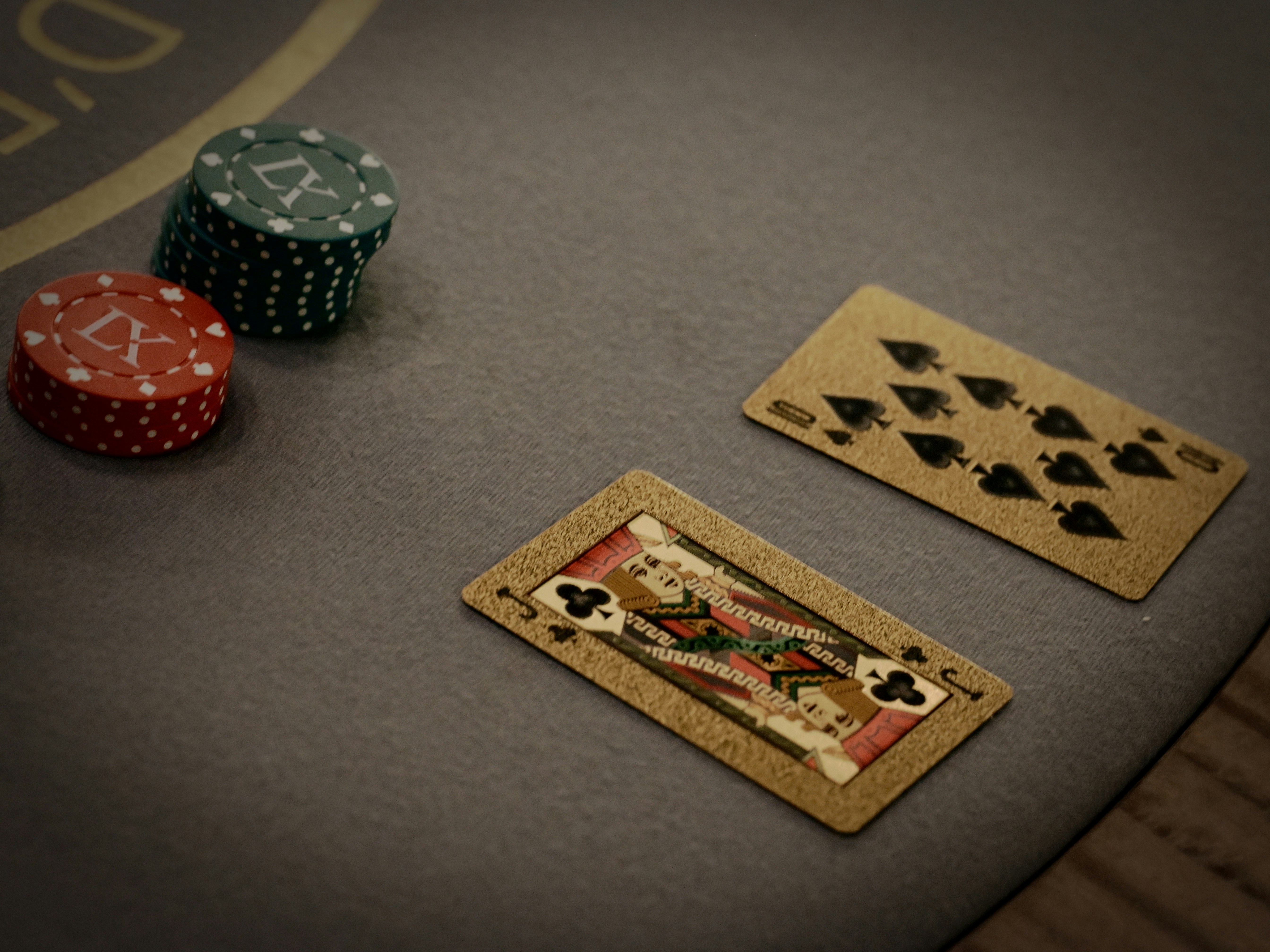 Two Poker Cards Face Down on a Velvet Table with Stacks of Chips