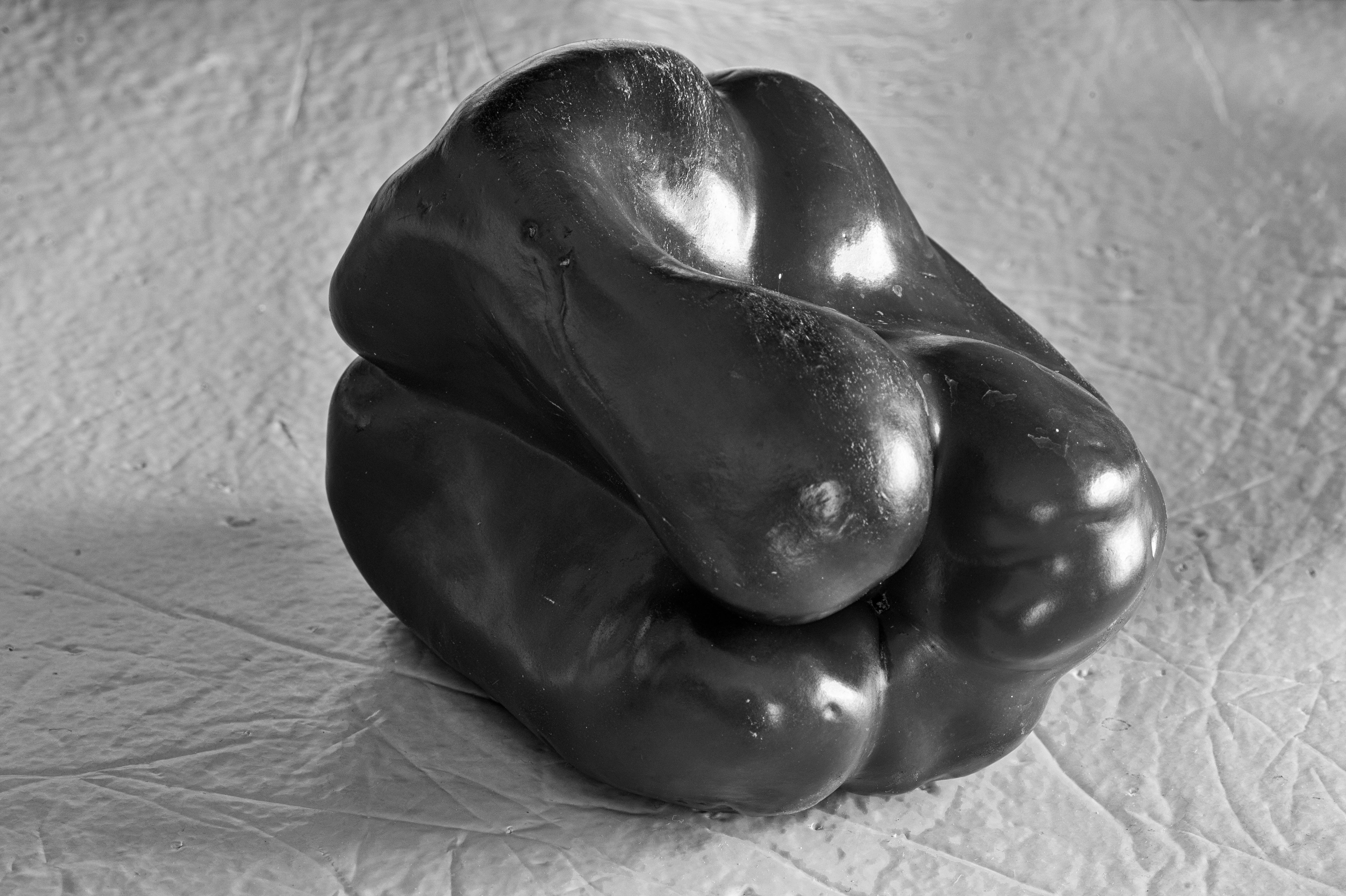Glossy Bell Pepper Knot Resting on Textured Surface