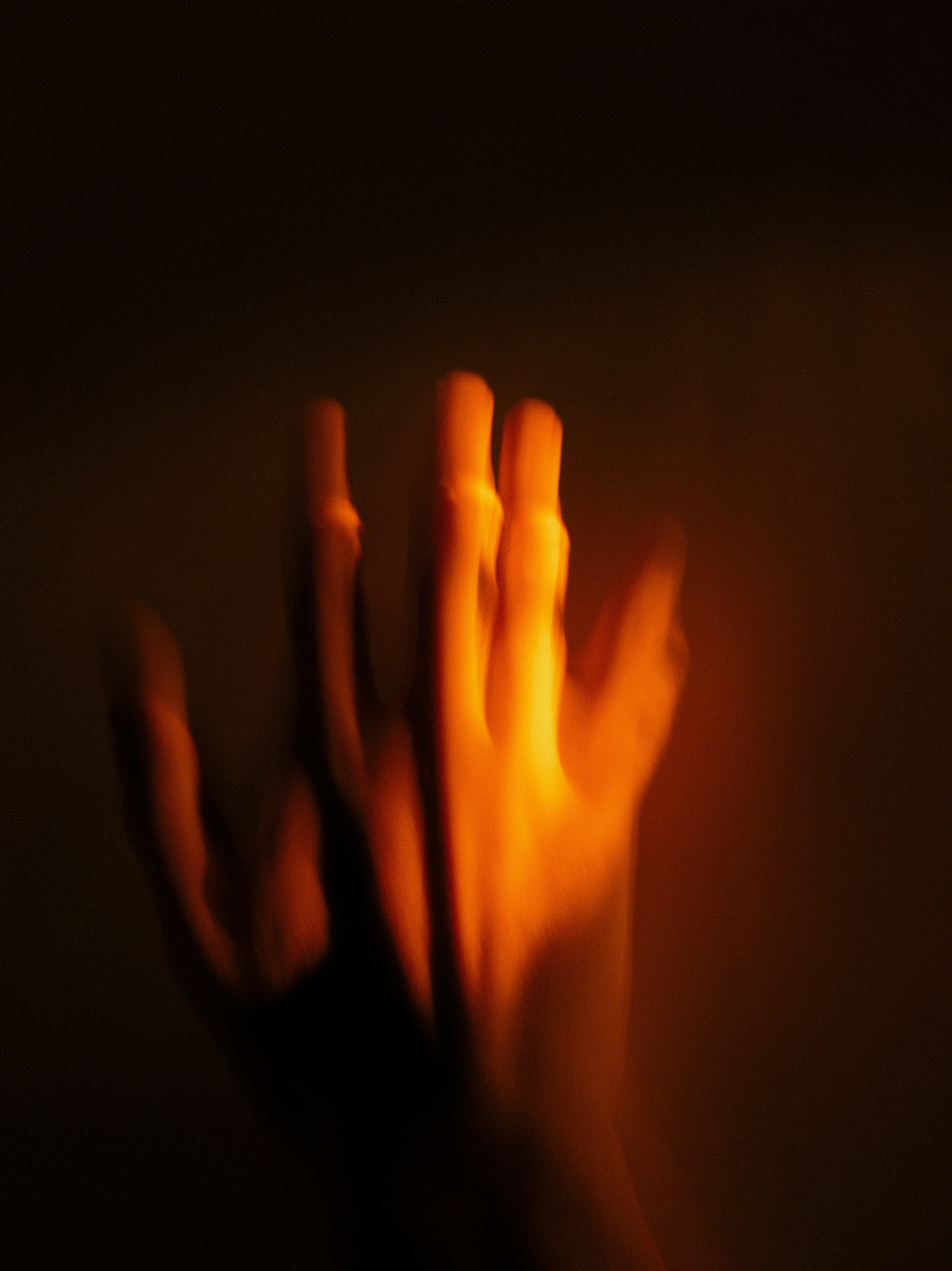 Blurred Flame: Hands Reach Through a Velvet Darkness