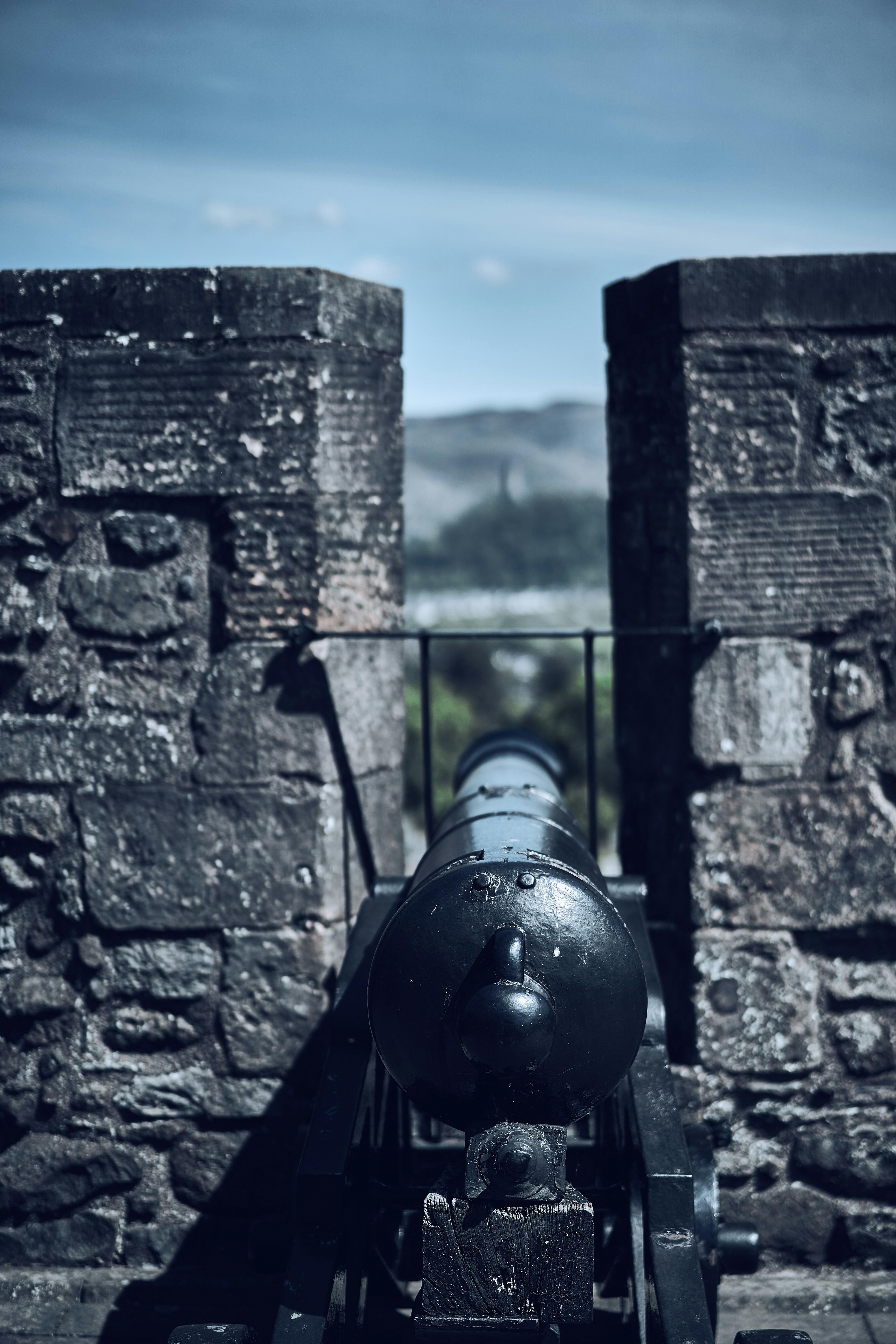 Midnight Sentinel: A Canon Pointed Through Stone Walls