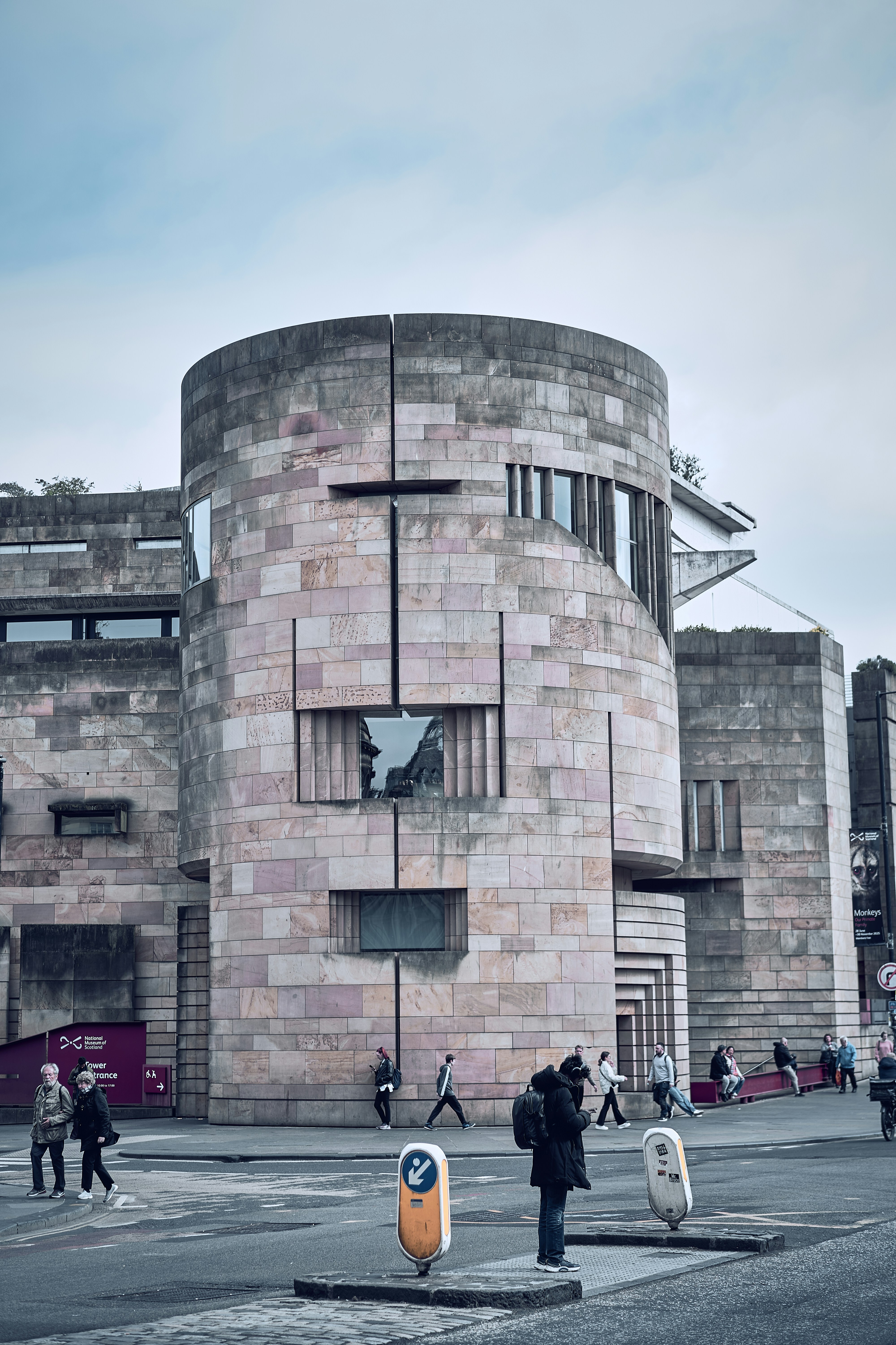 Circular Stone Facade: People and Passage by a Modernist Monument